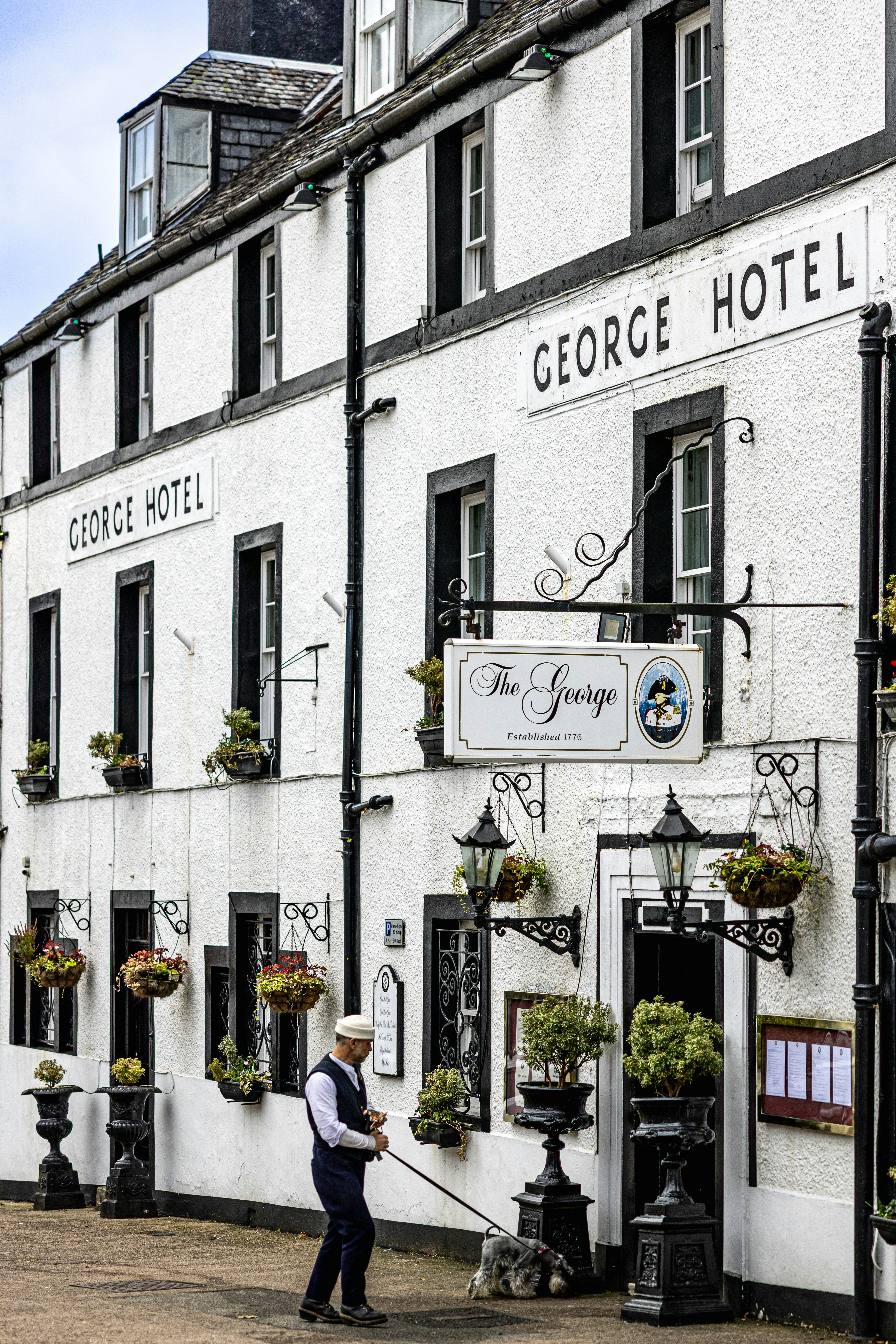 George Hotel Front: A Gentleman Walks a Dog by Lanterns
