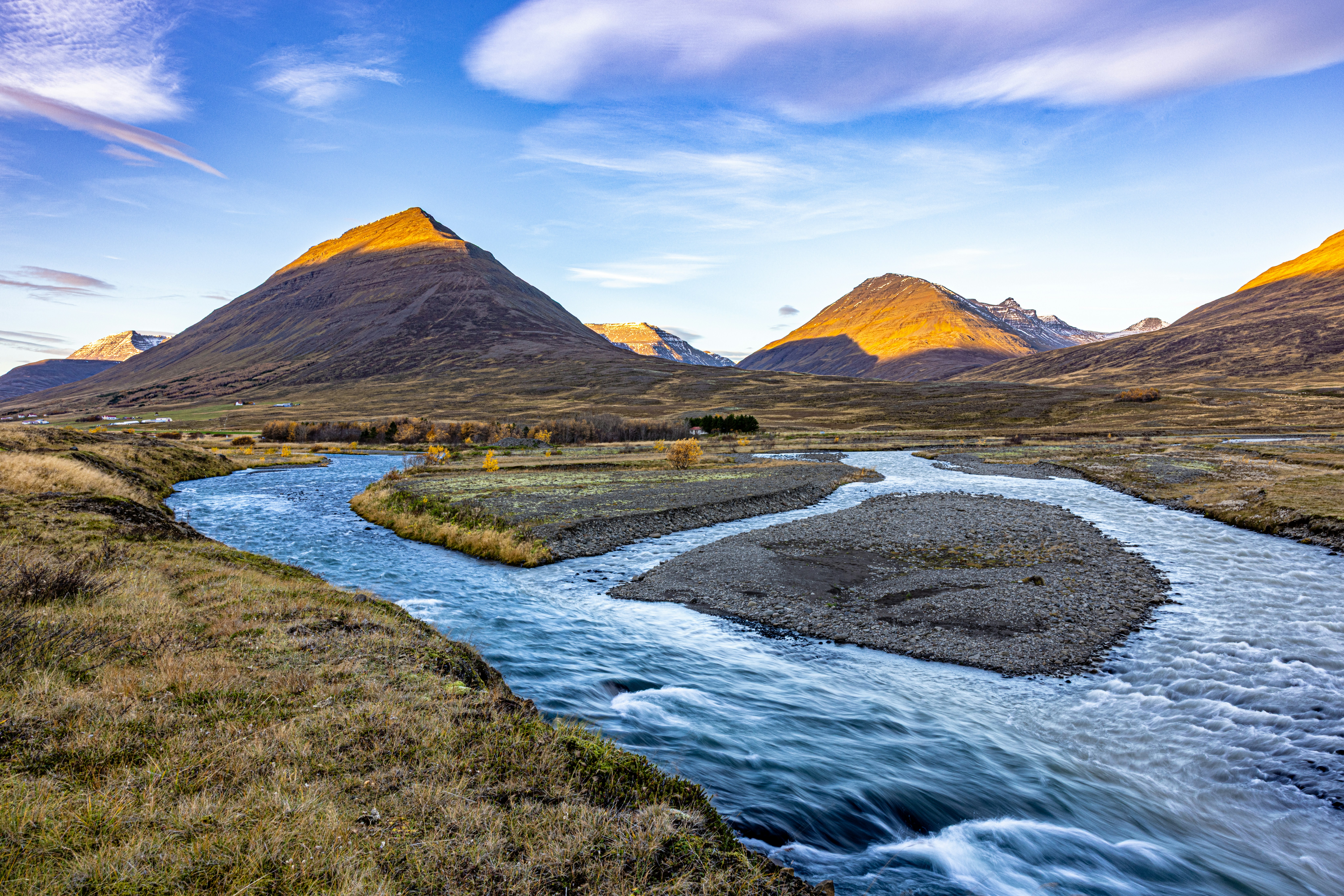 Sunlit Peaks Over a Meandering River