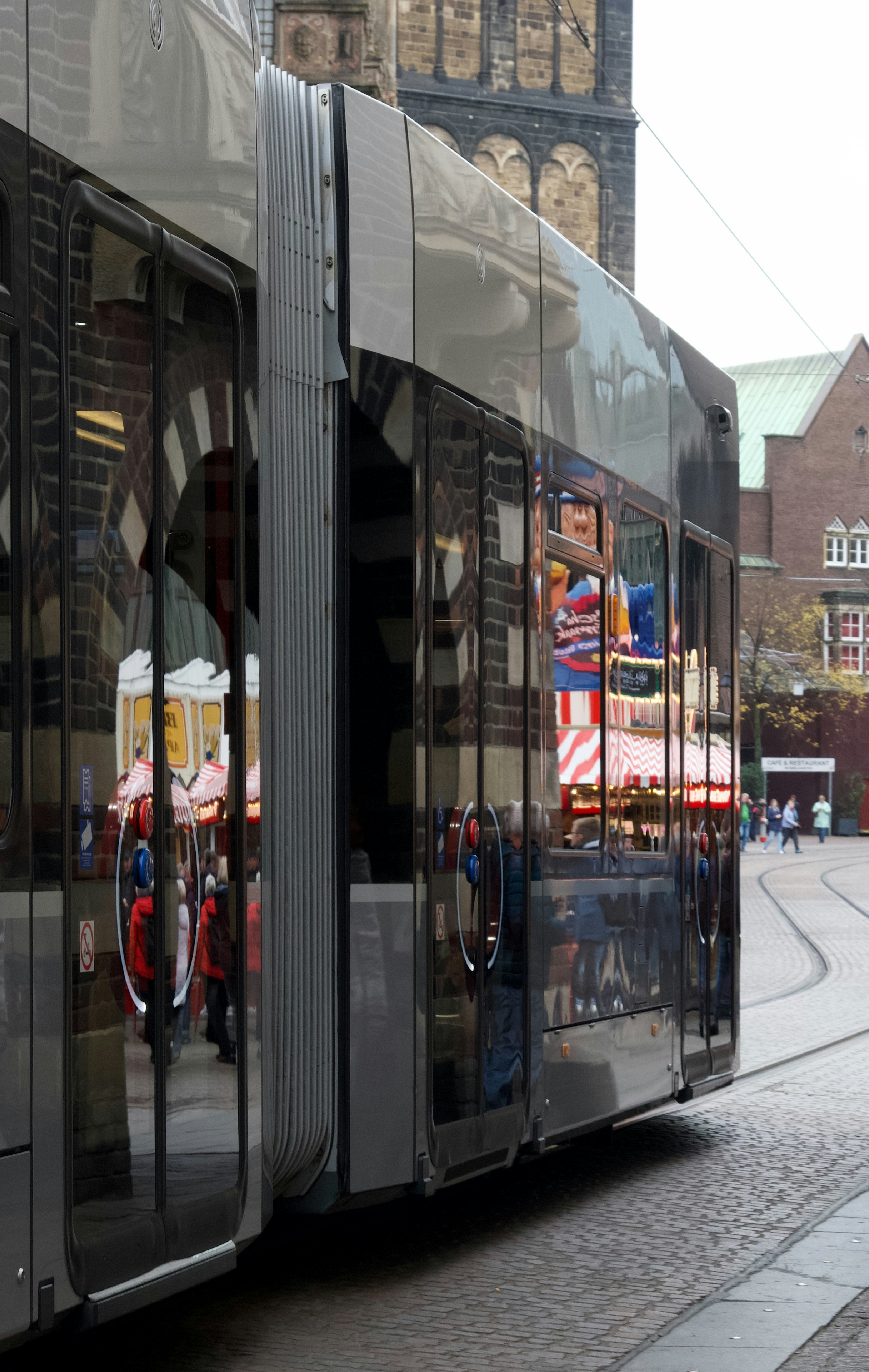 Reflective Tramline: A Modern Carriage at a Cobble Street Corner