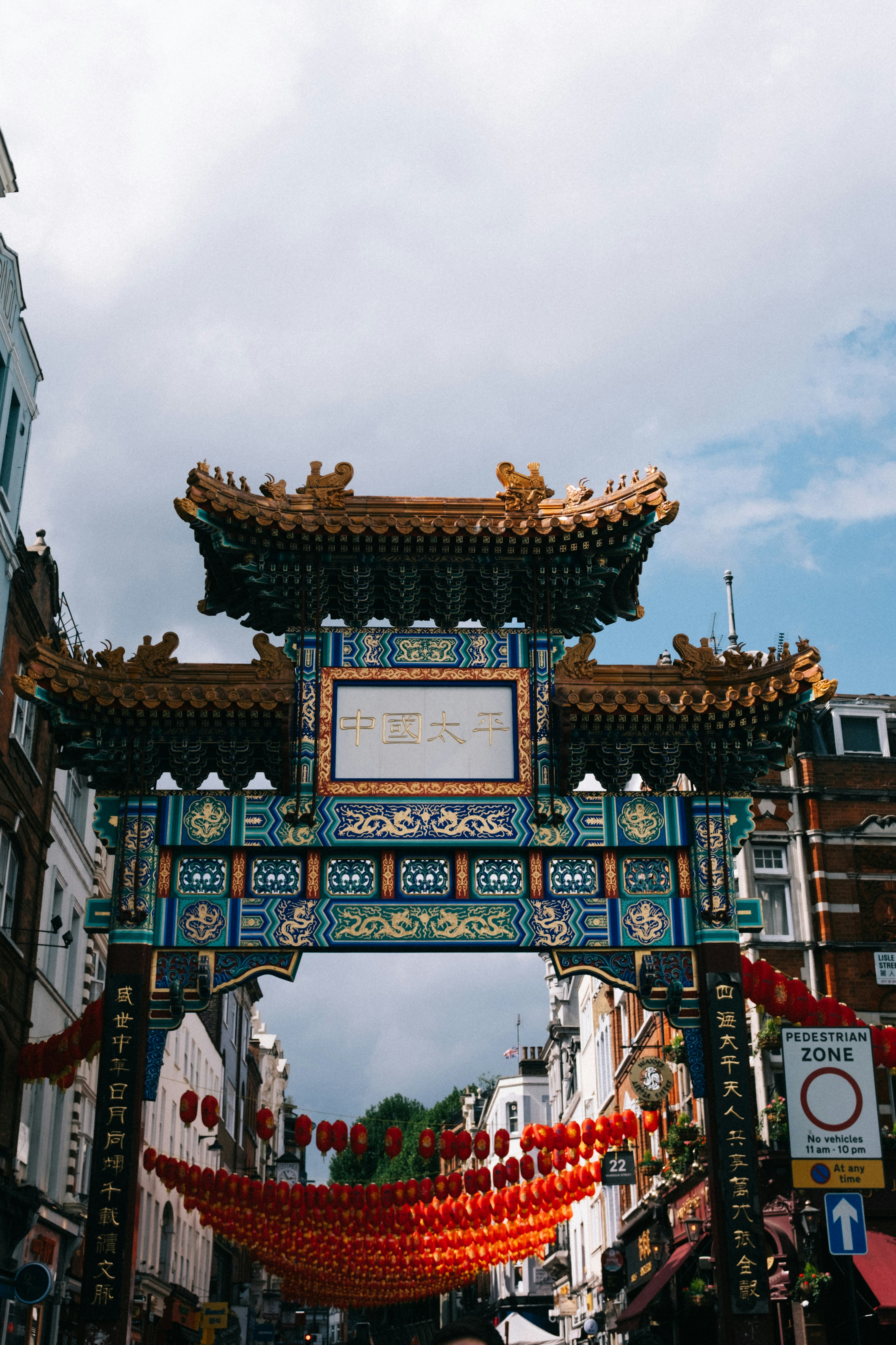 Dragon-Guarded Gateway: A Chinatown Arch Under a Ribboned Sky