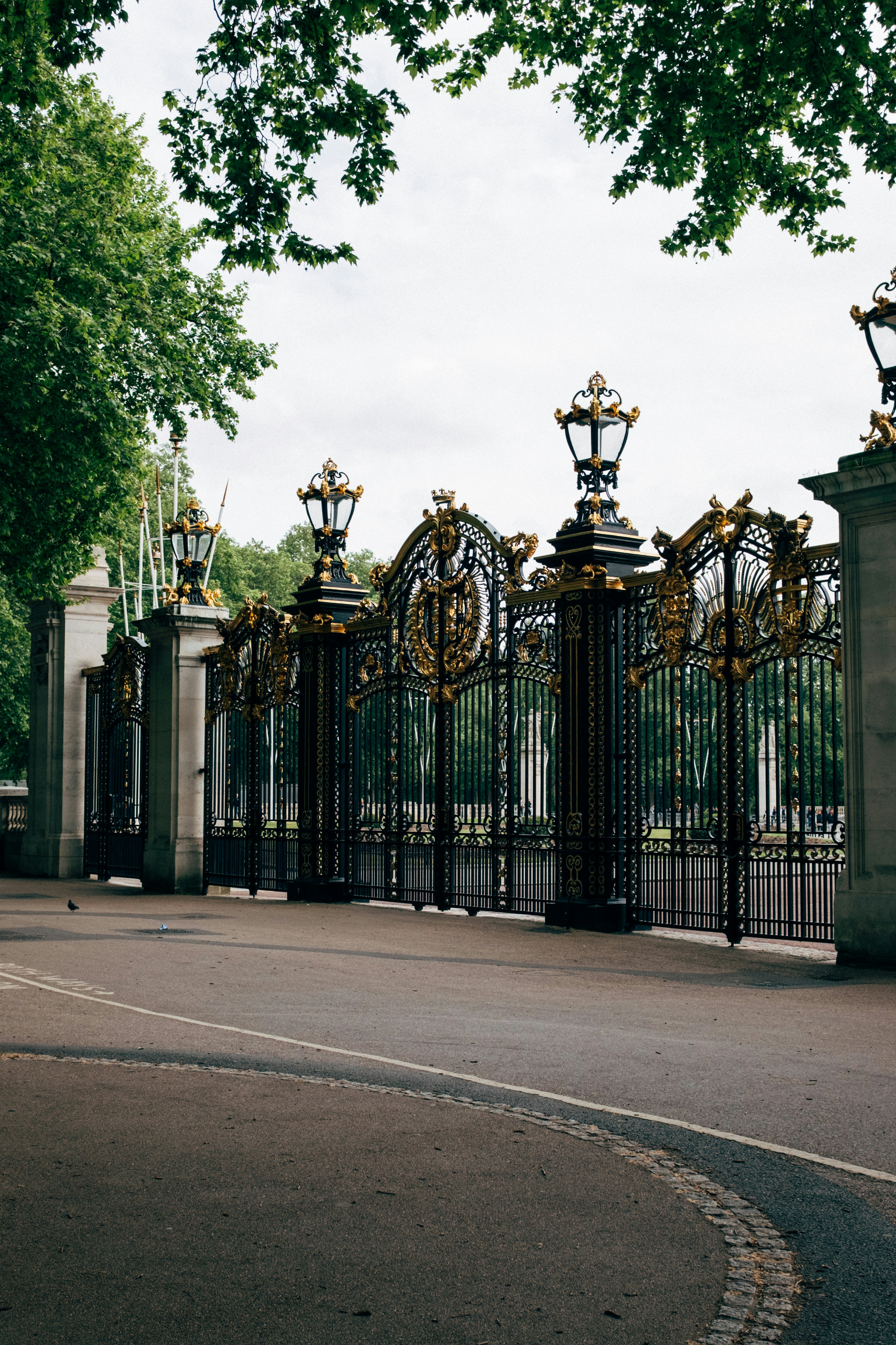 Ornate Gates of Time: A Quiet Street Framed by Gold-Topped Fences