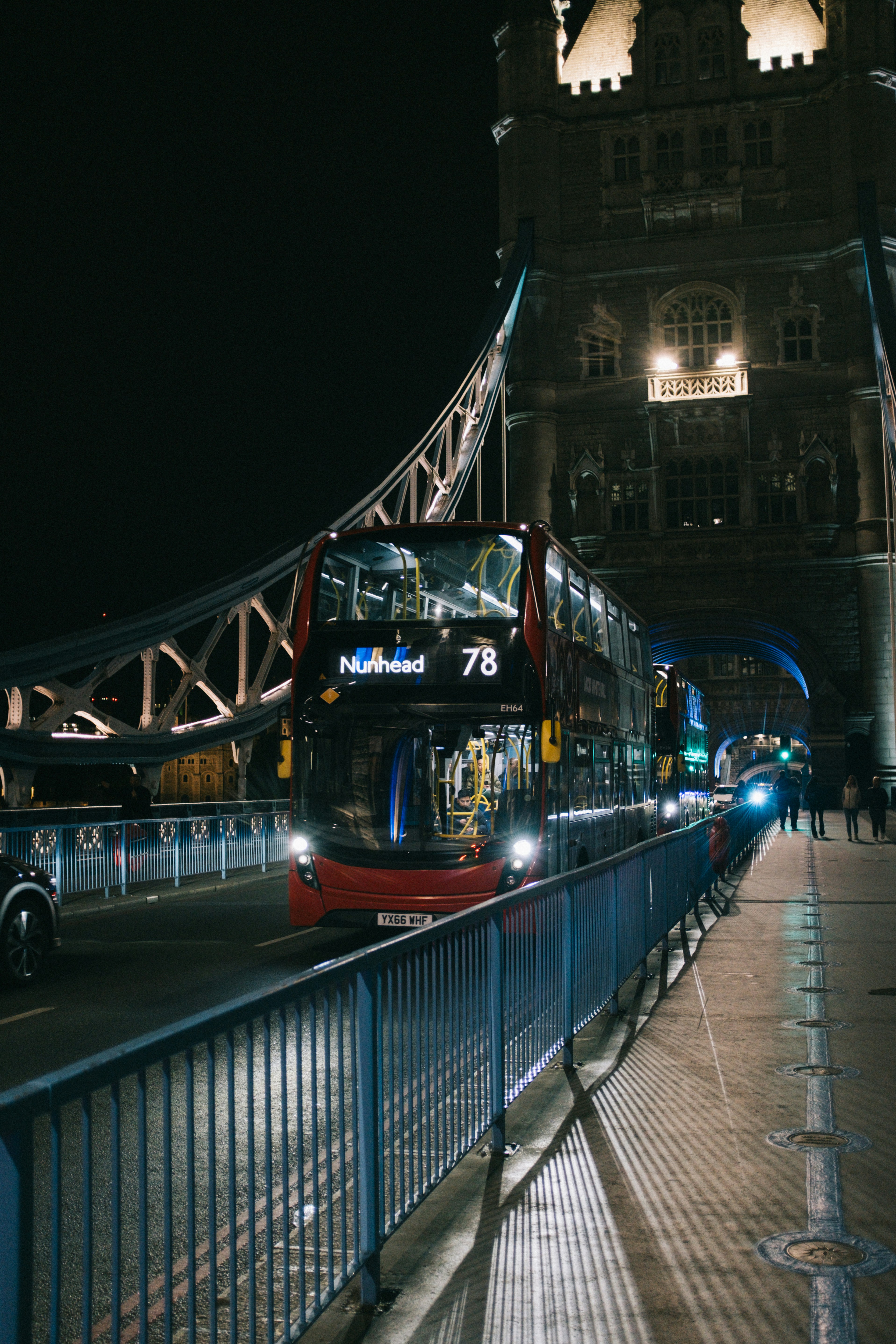 Night Bus on Tower Bridge: A Red Double-Decker Under Illumined Arches