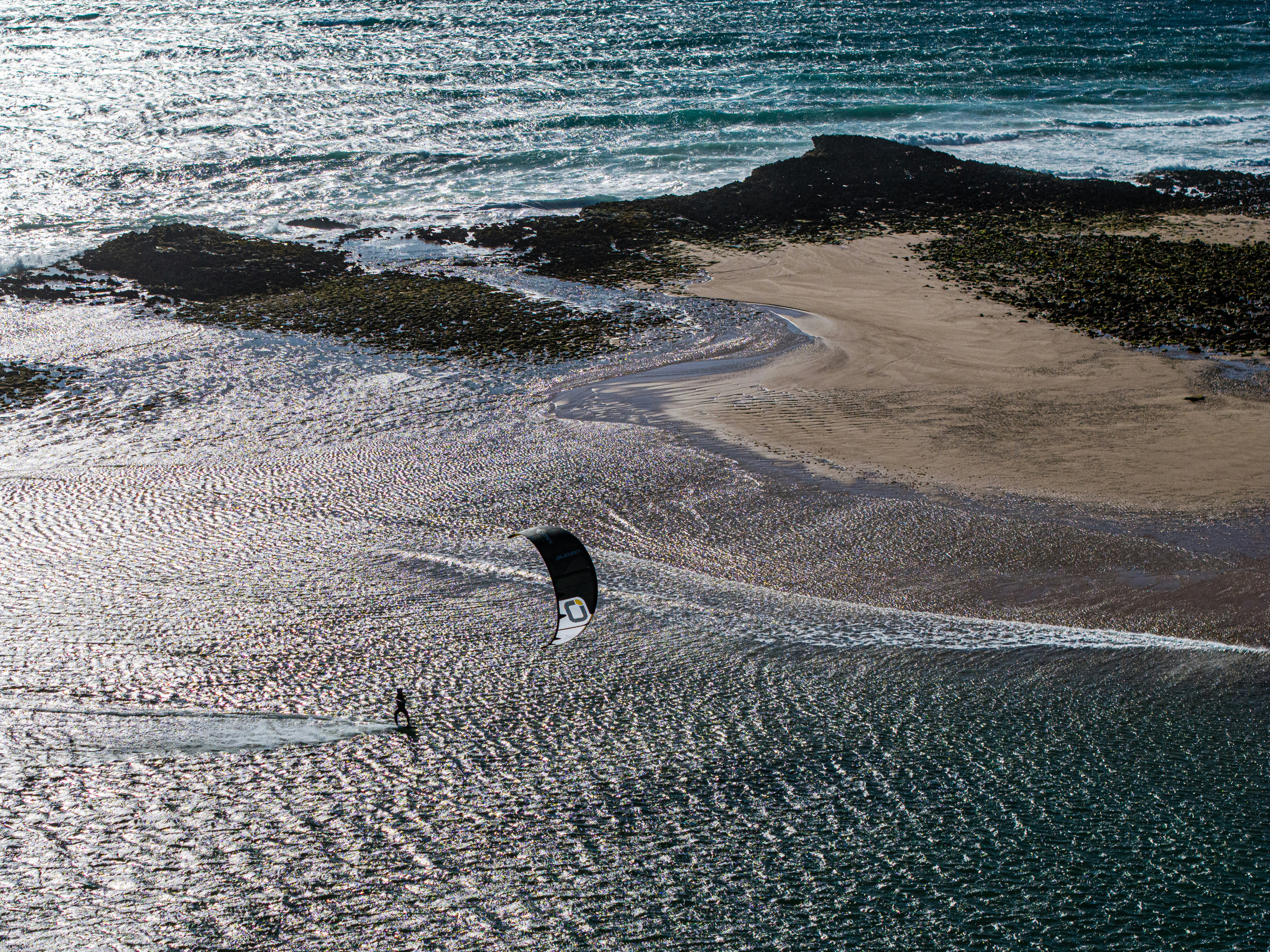 Kite Surfer Trace Across A Sunlit Shore