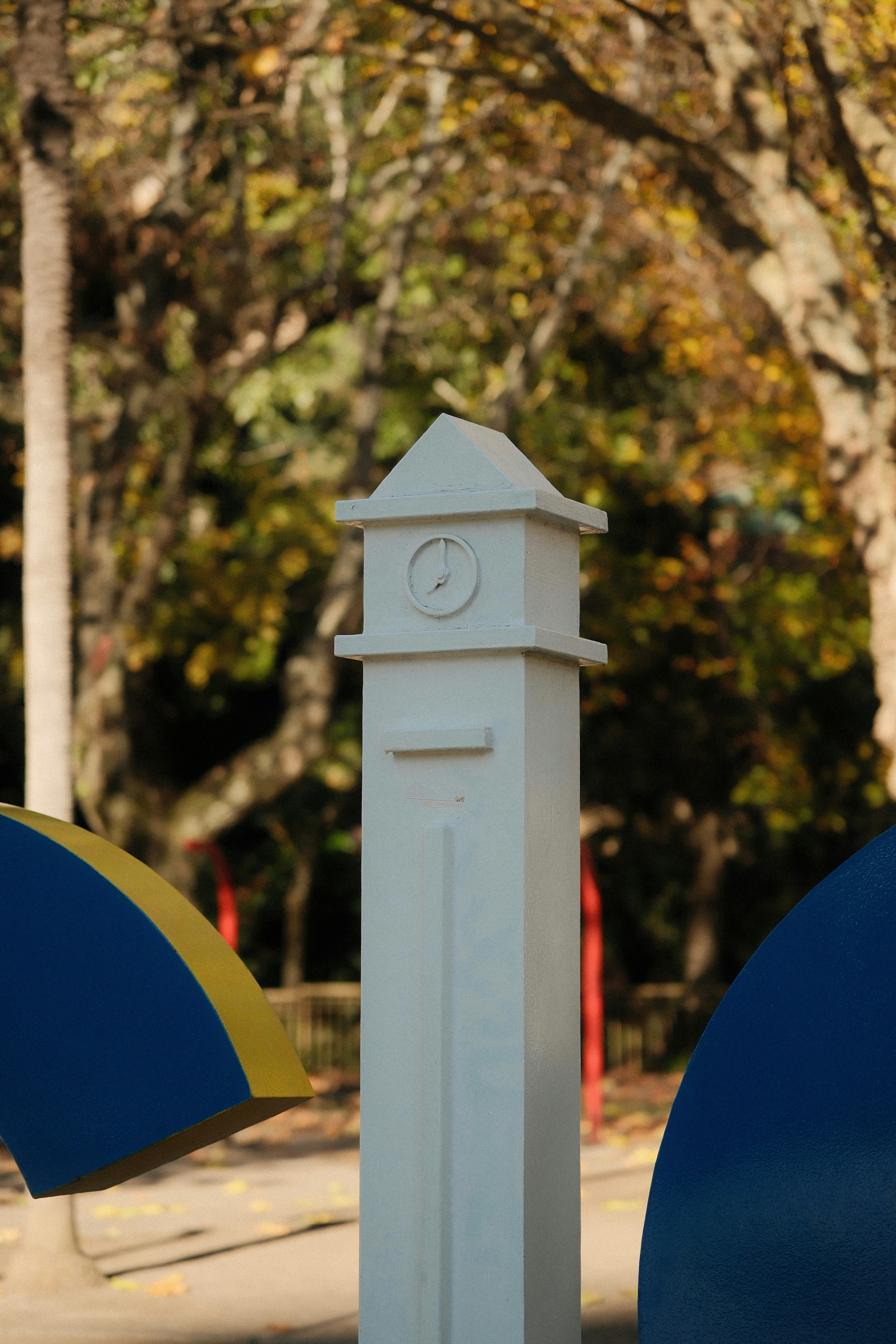 Center Pillar of Calm: A White Post Framed by Playground Arches