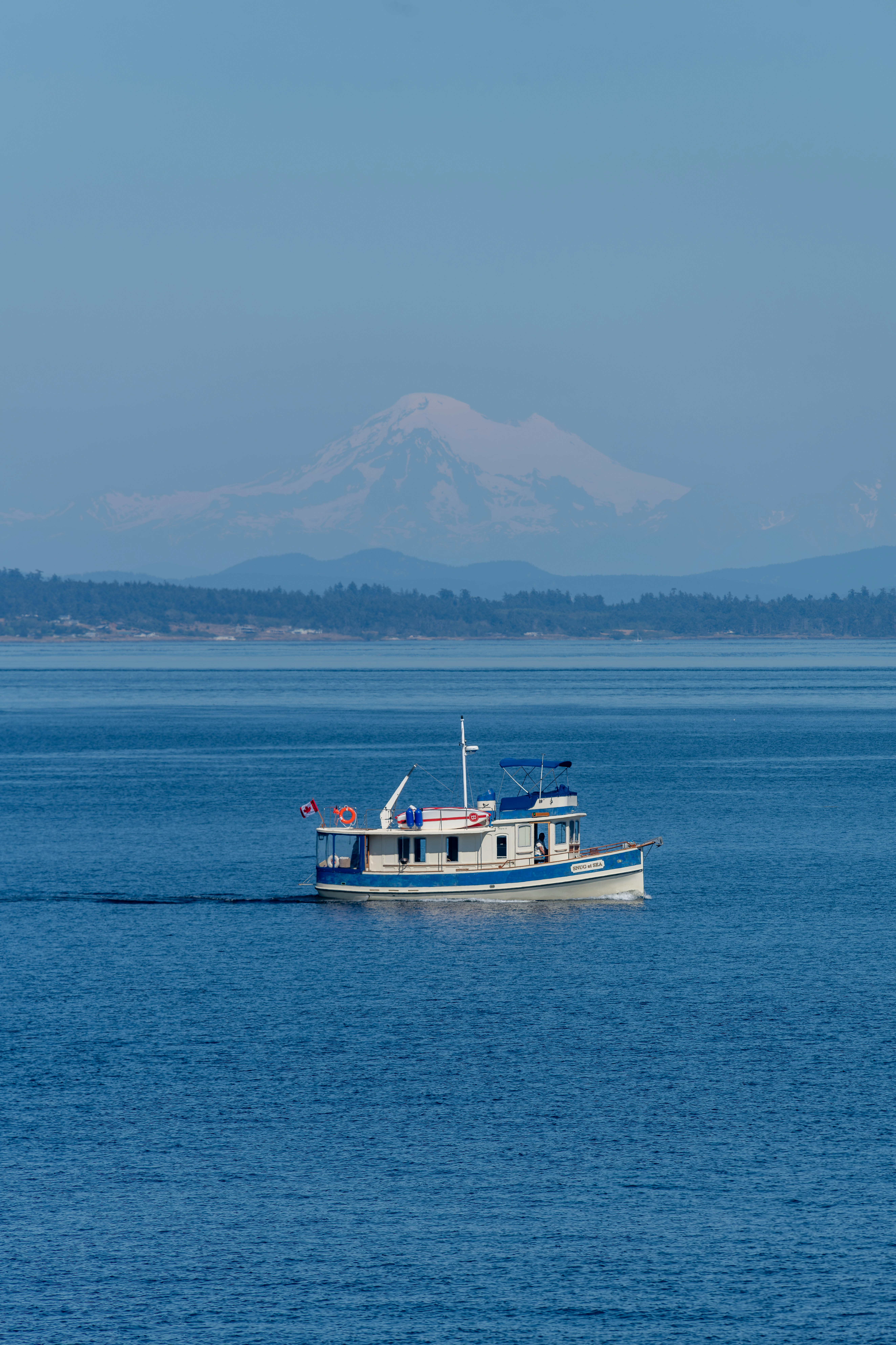 Blue Water Passage: A lone boat under a distant snowfield