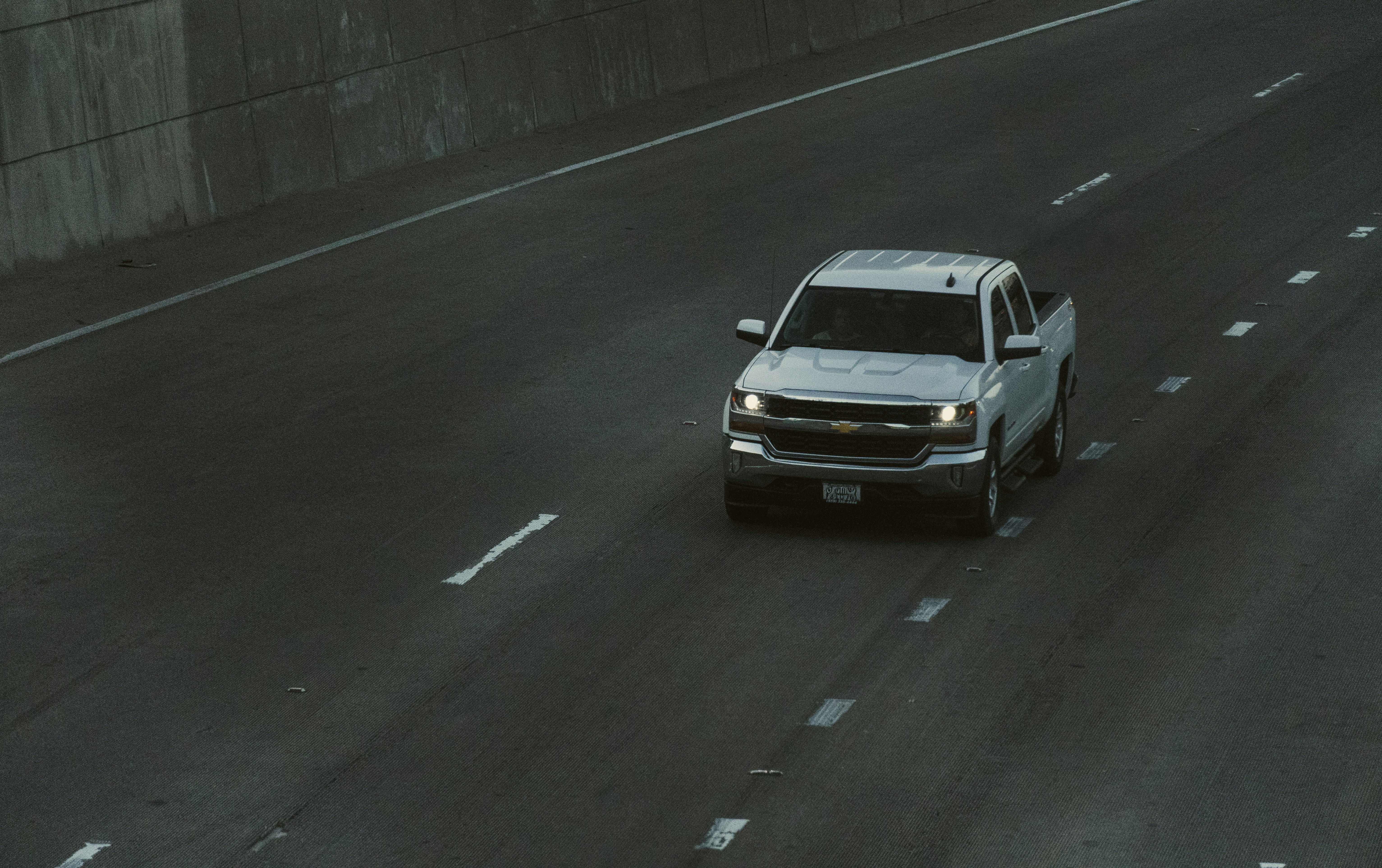 Highway Chase: White Pickup Surges Through a Quiet Concrete Corridor