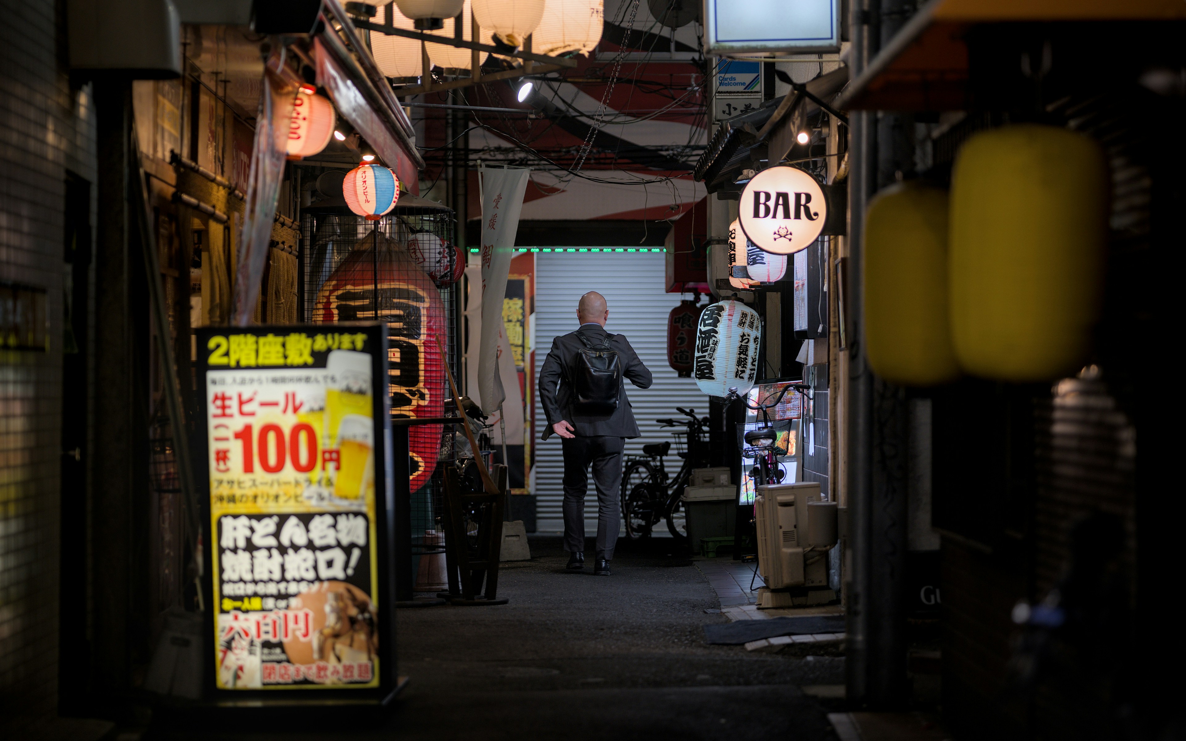 Neon Alleyway Return: A lone traveler navigates a dim Japanese street