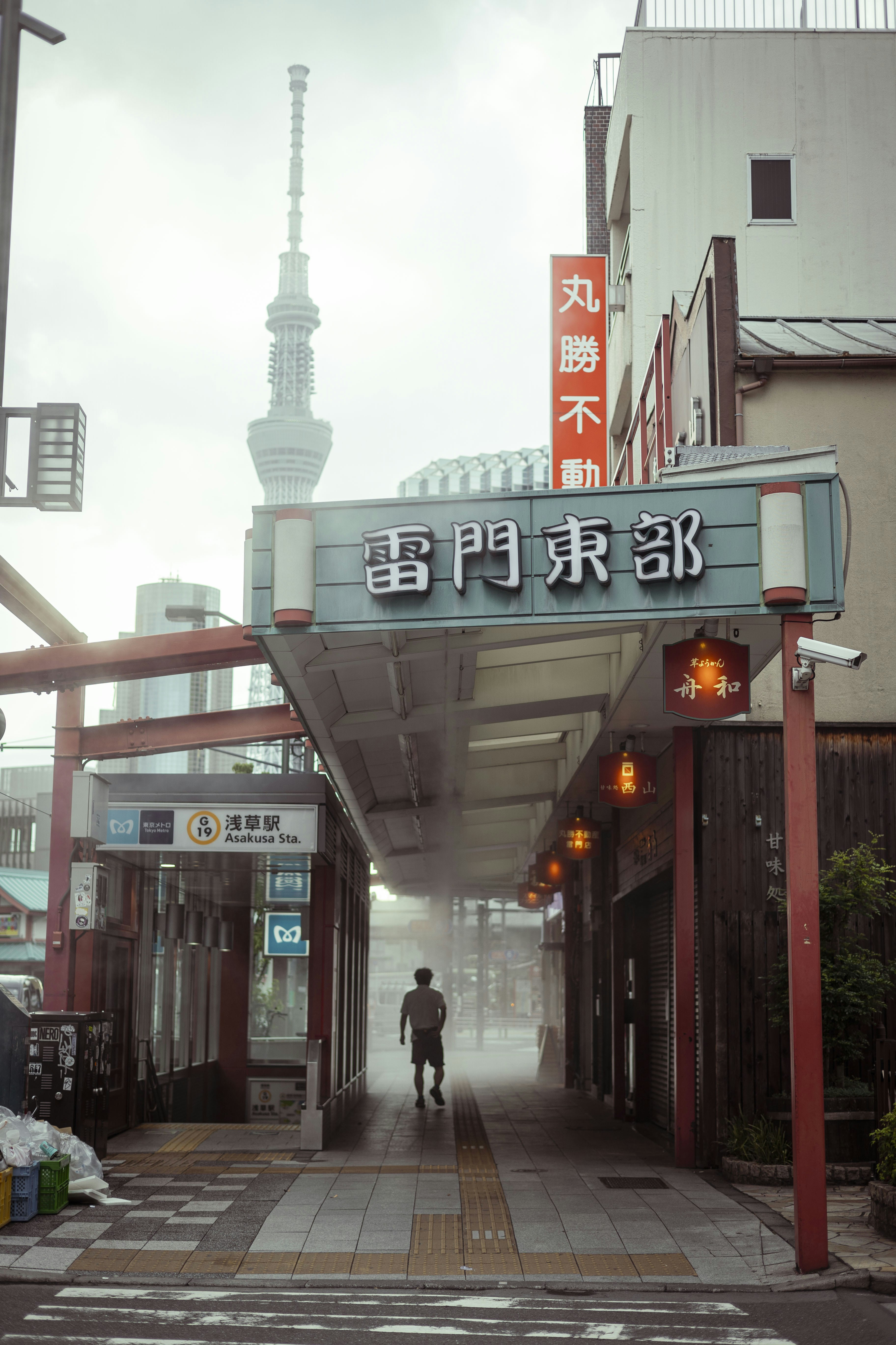 A lone person walks through a misty street in japan.