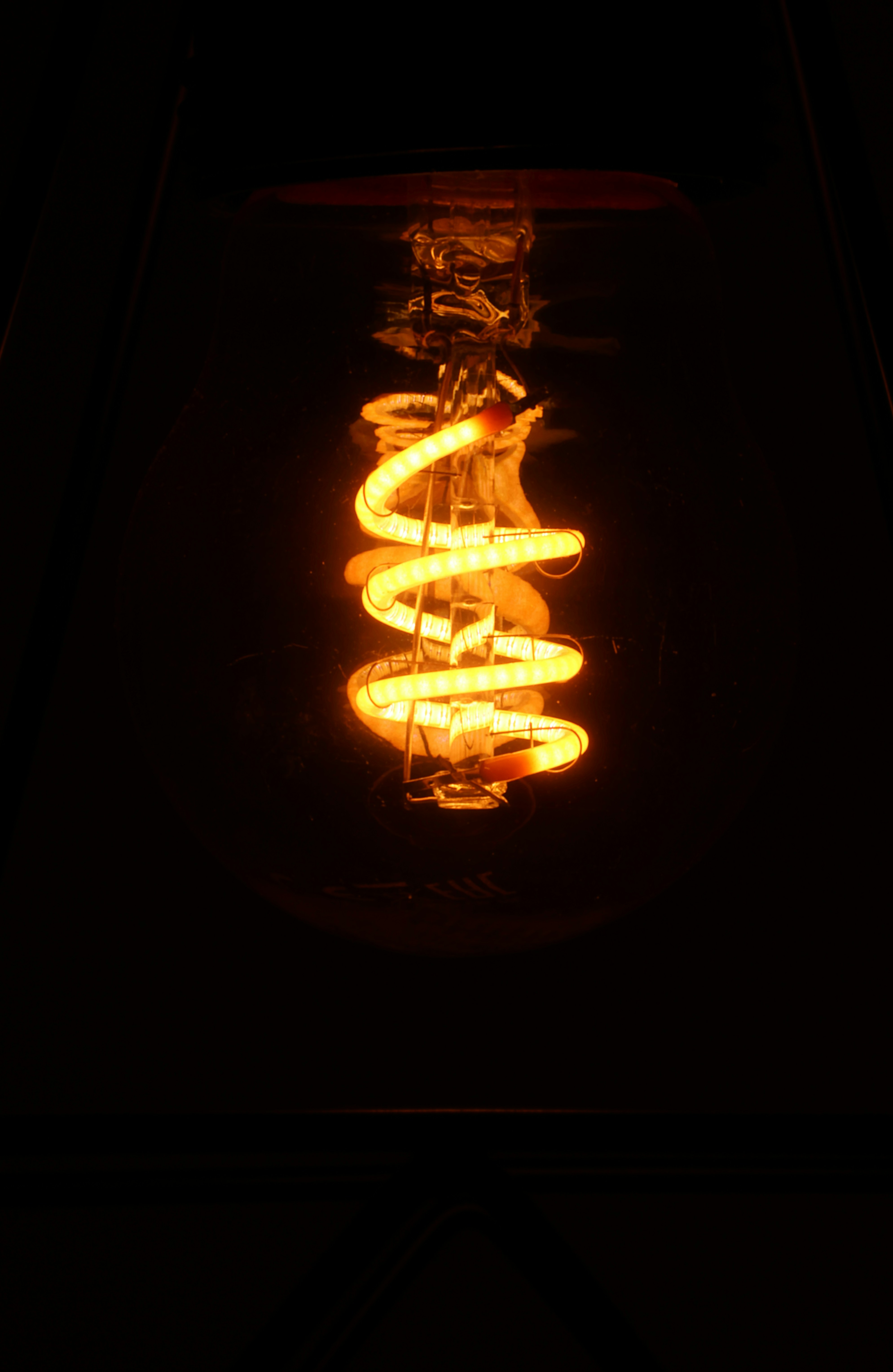 Incandescent Spiral: a Closeup of a Vintage Filament in Low Light
