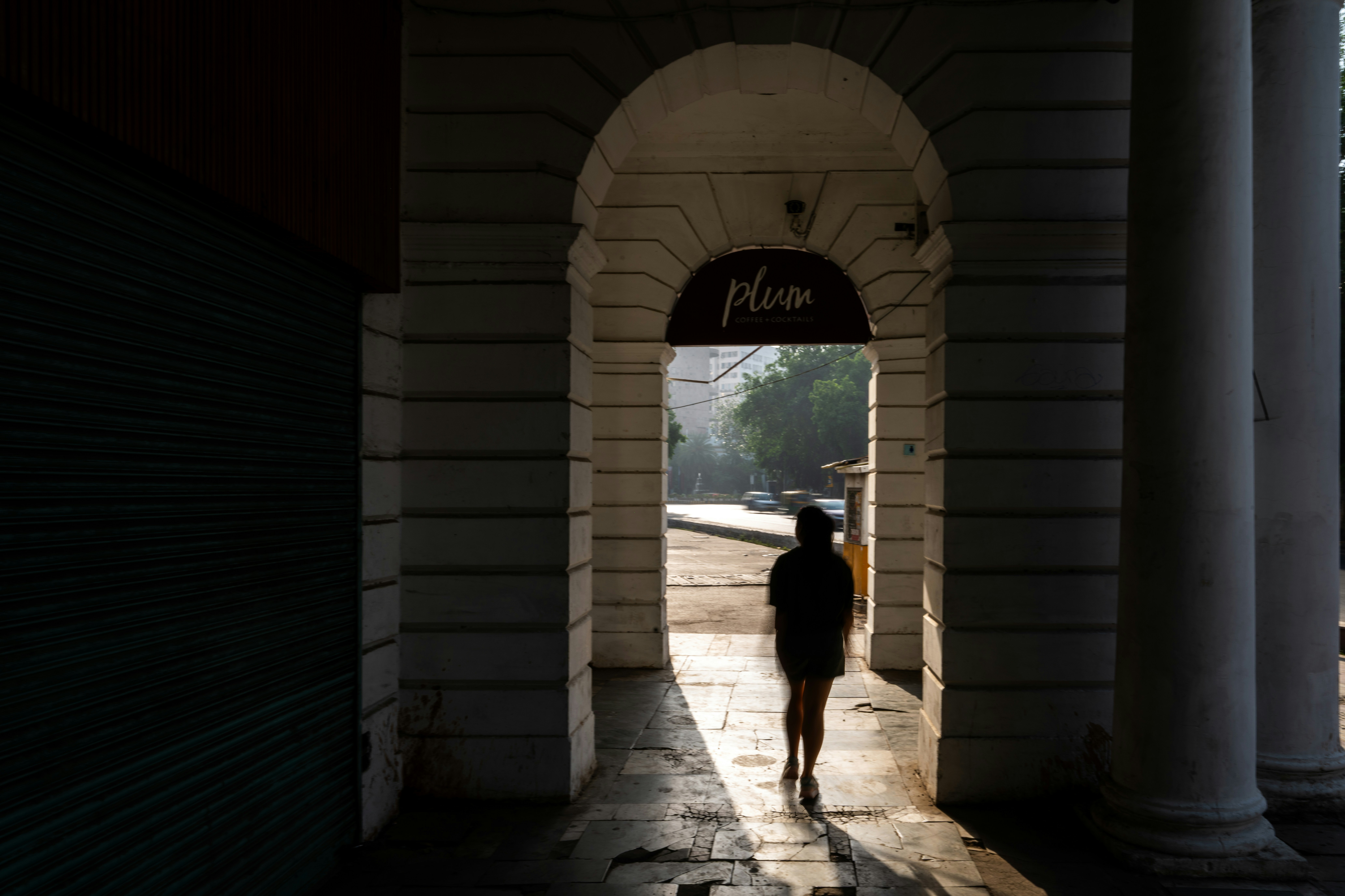 Silhouette in the Archway: A Sunlit Passage