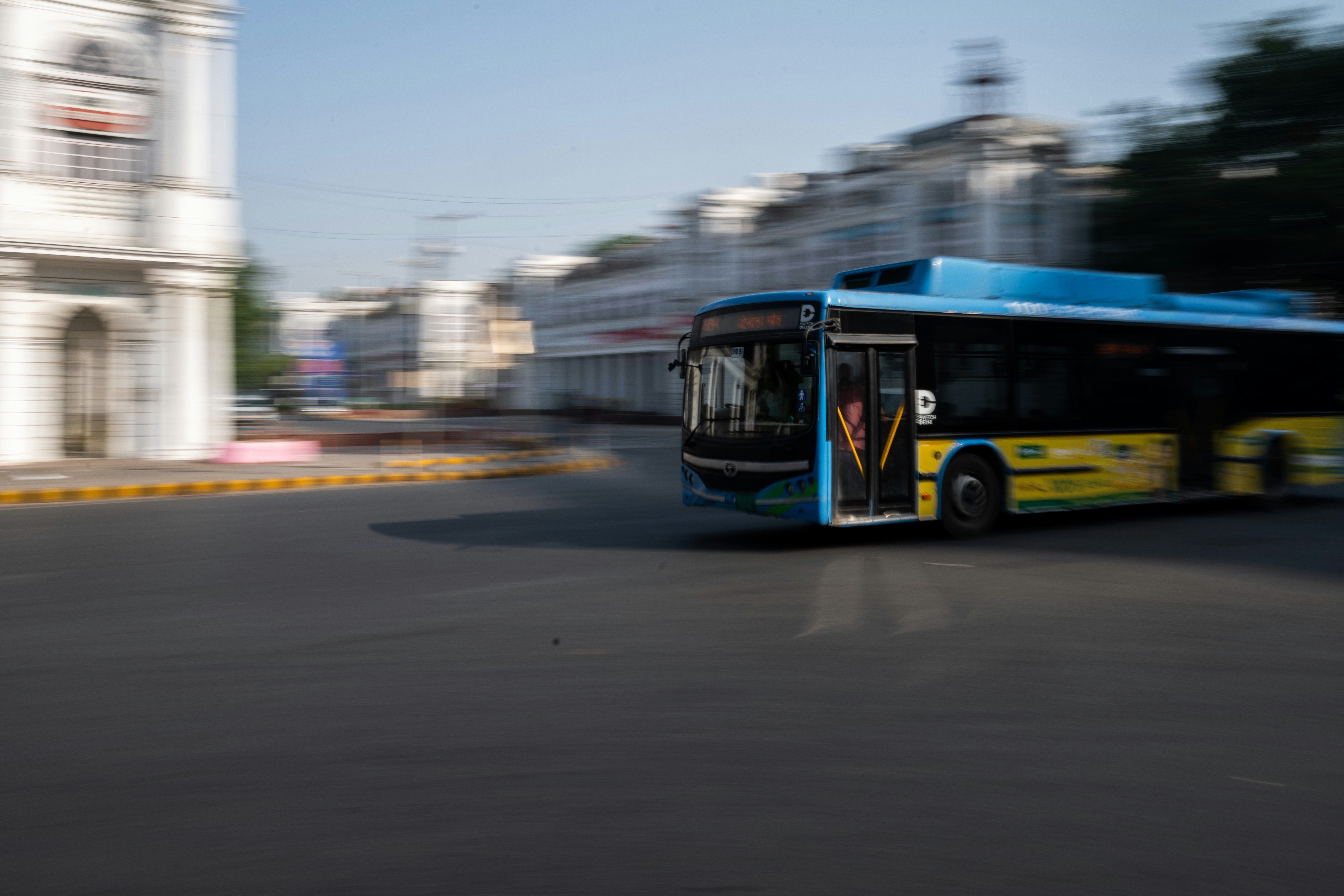 City Bus in Motion: Blue Transit Sliding Through a Sunrise Street