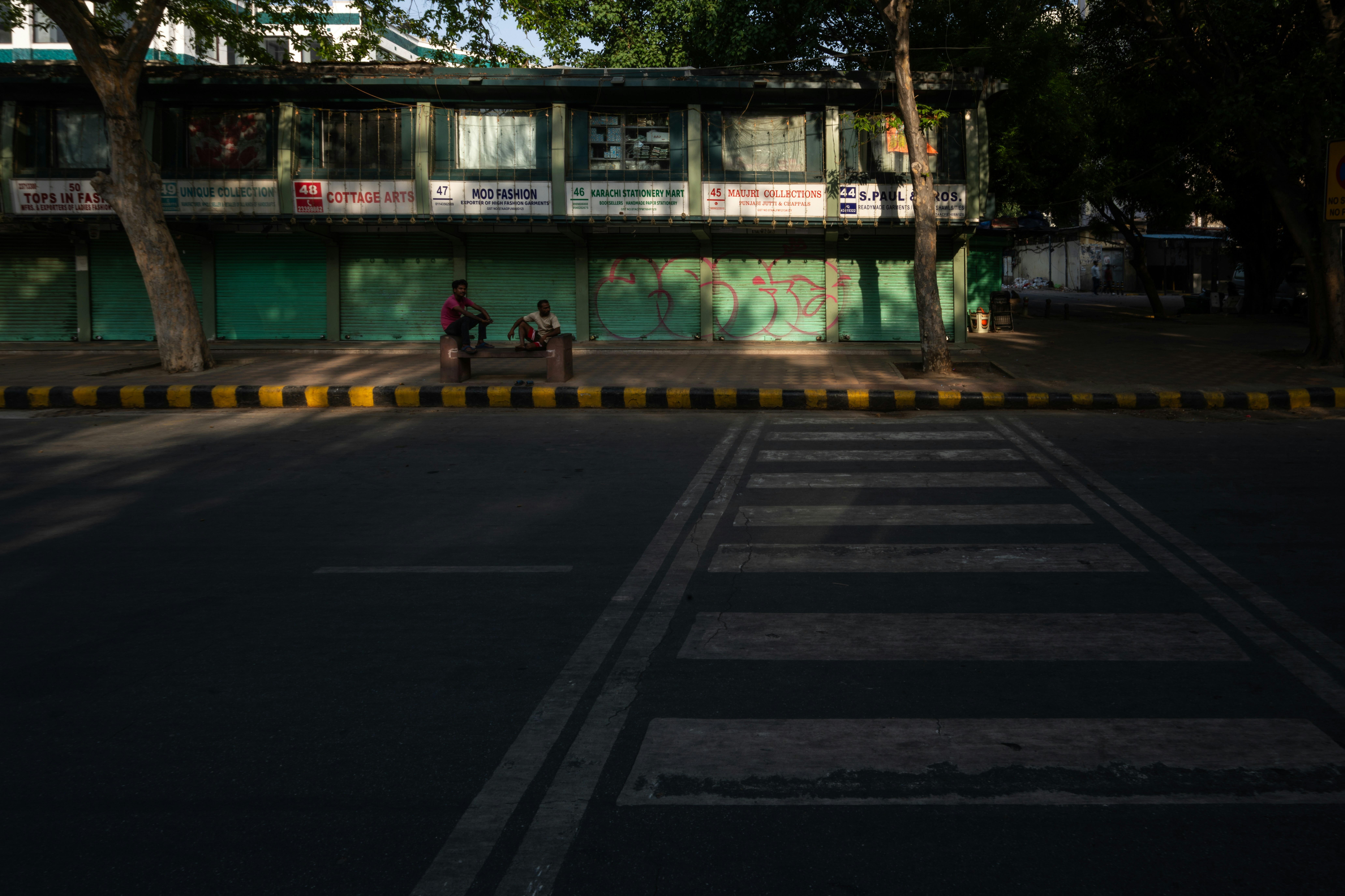 Dawn on the Quiet Crosswalk: Two Pedestrians and a Sunlit Facade