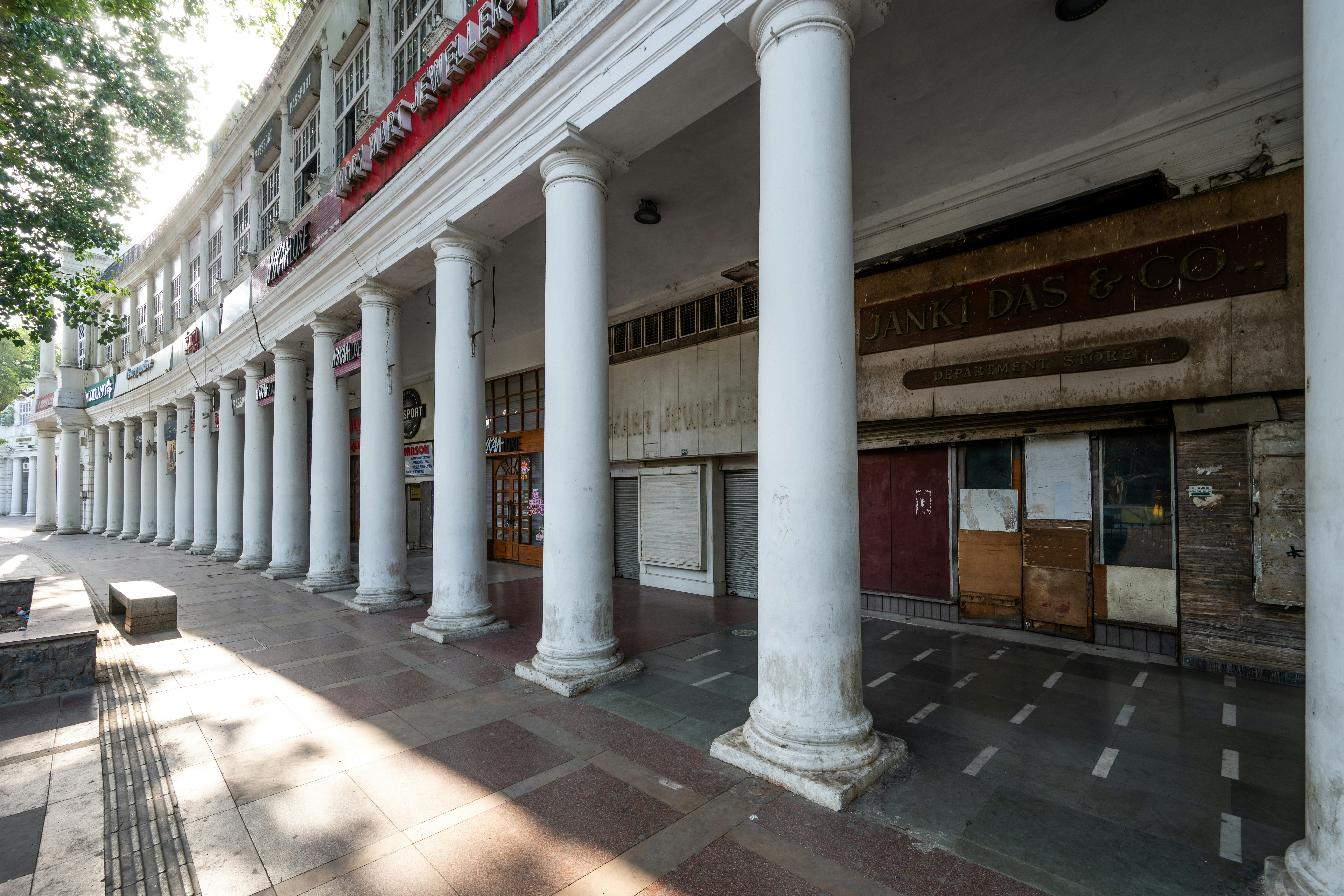 Colonnade Echoes: Sunlit Arcade of Closed Shutters