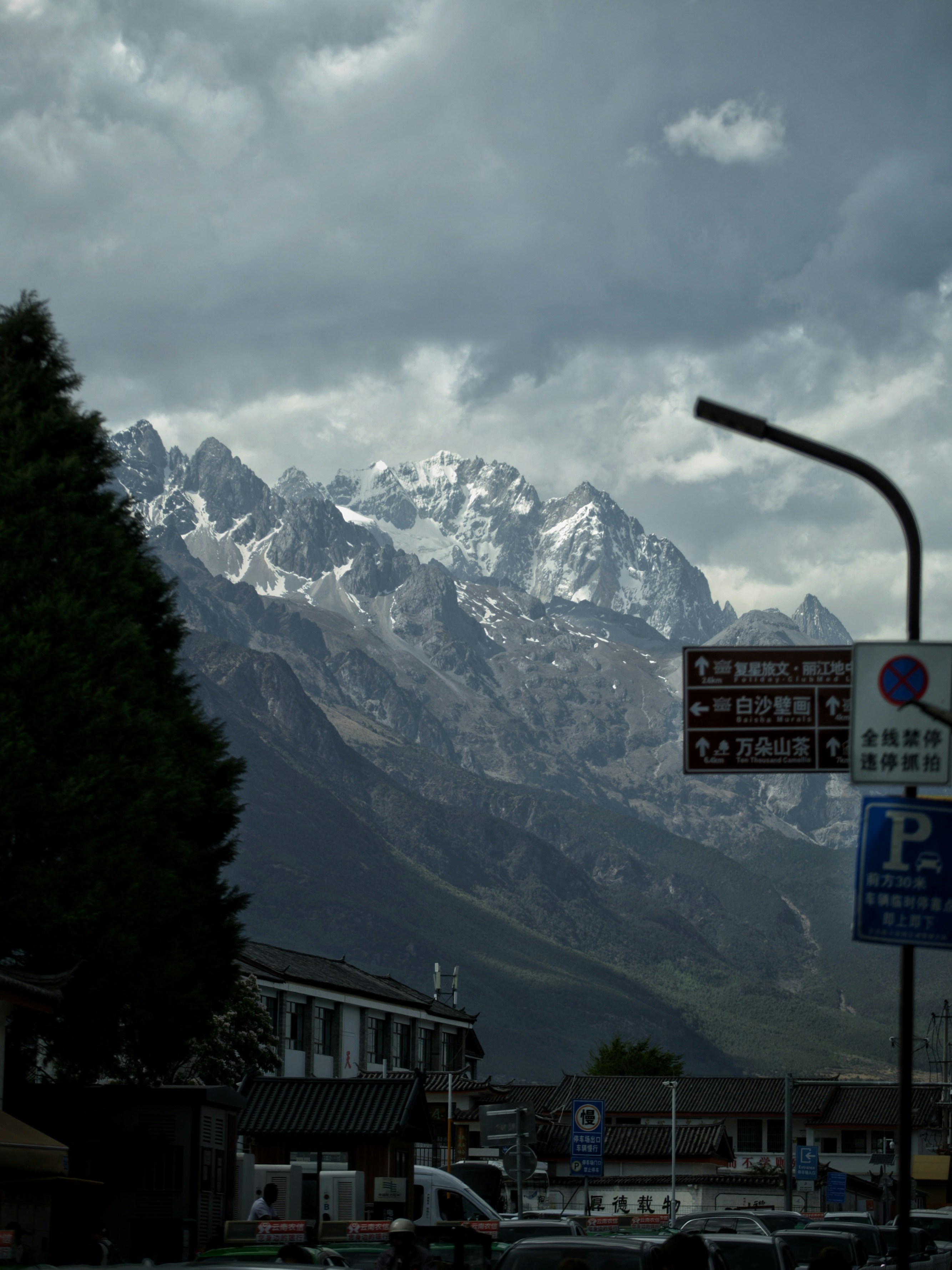 Snow-kissed peaks loom over a quiet street and sign-lit intersection
