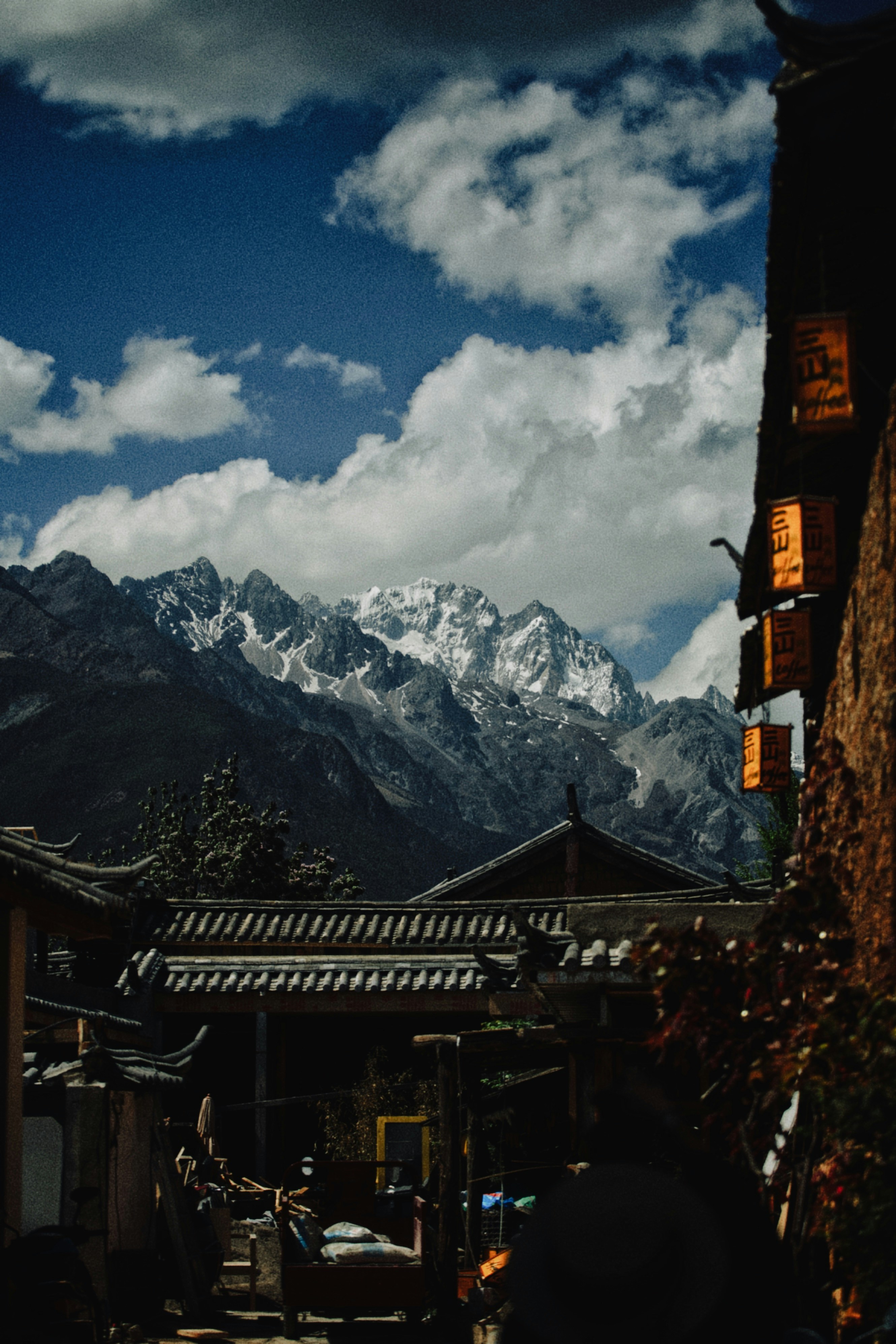 Snow-capped Peaks Framed by Traditional Rooflines in a Mountain Village