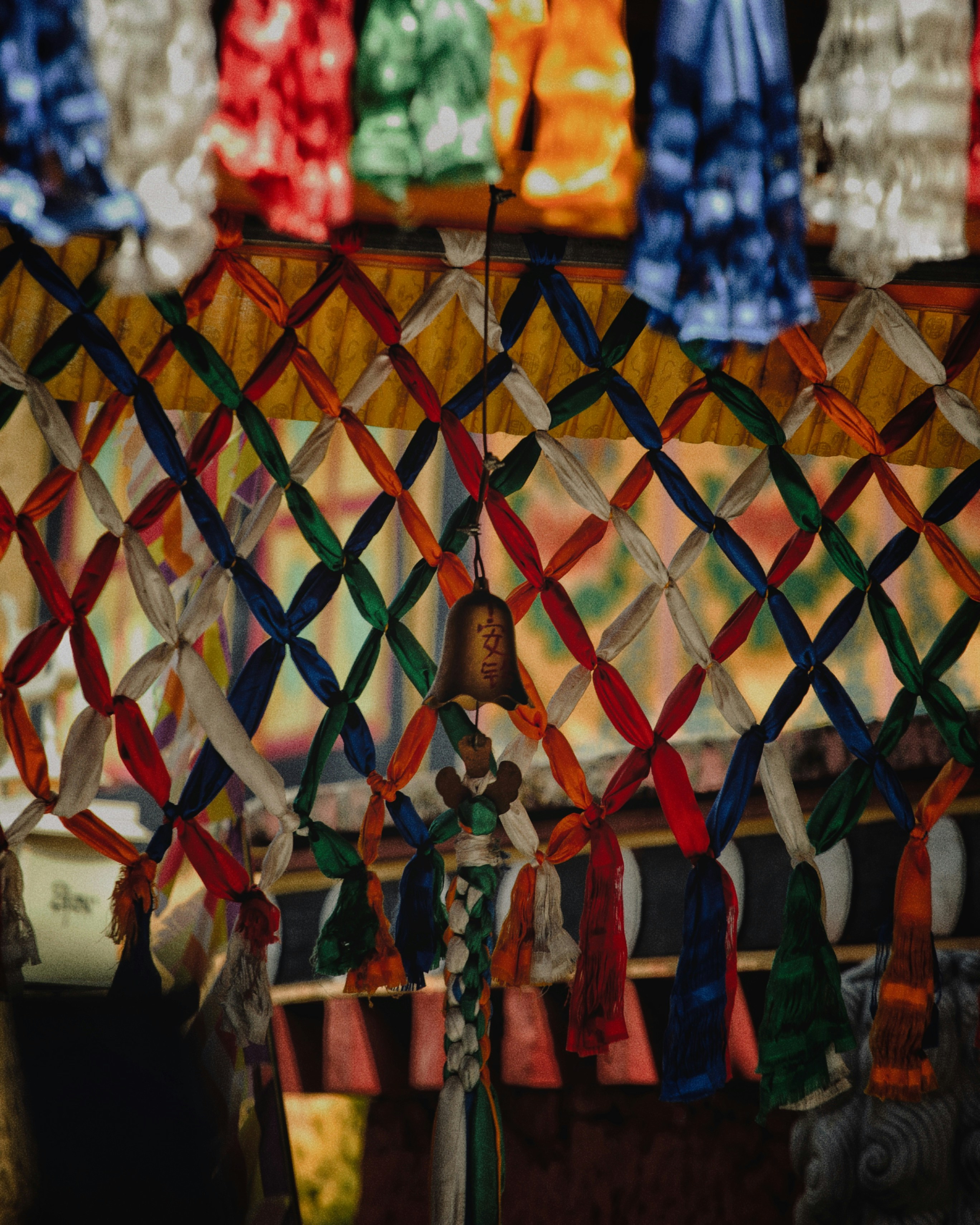 Colorful prayer flags weave a suspended mosaic over a shrine
