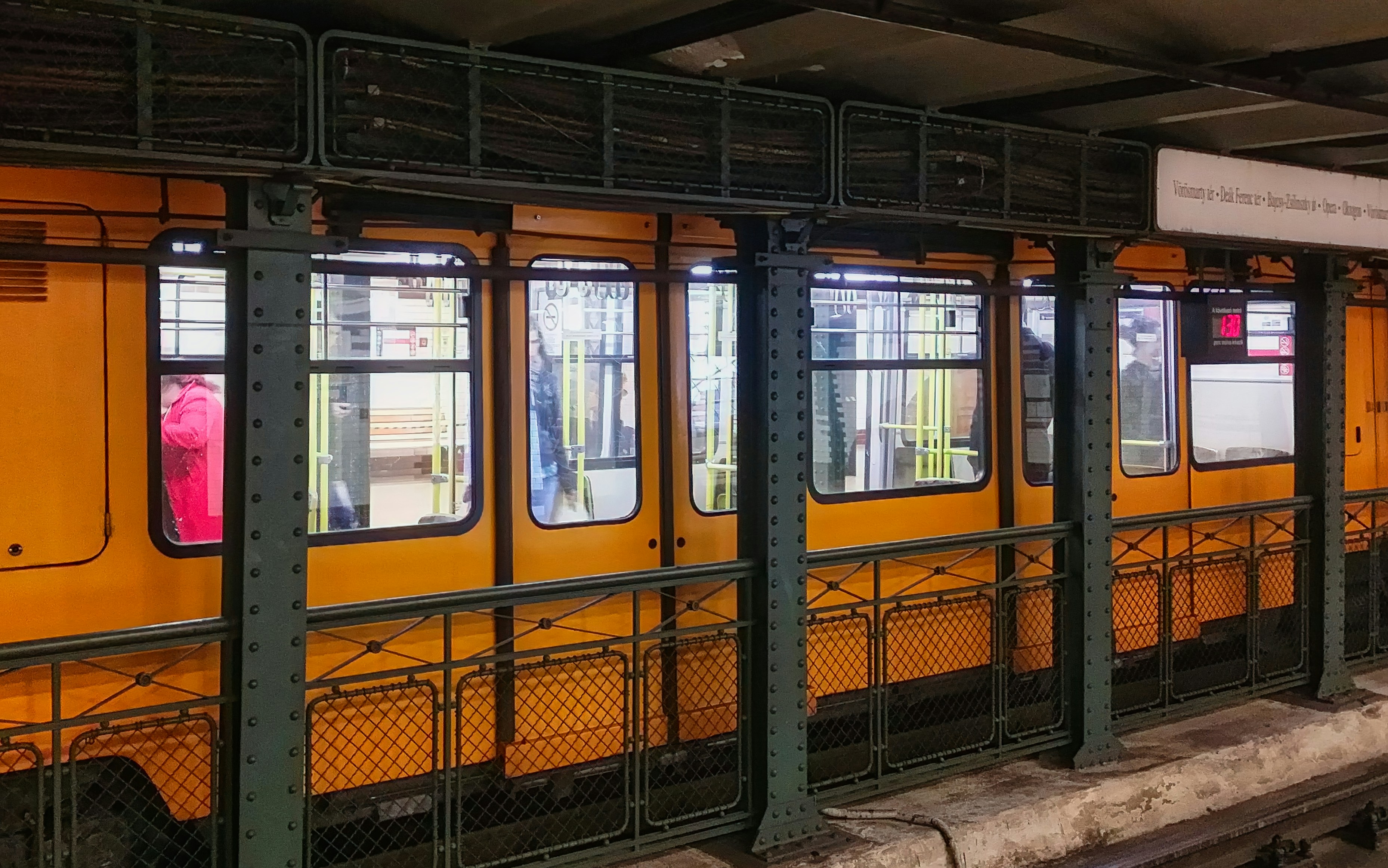 A yellow subway train stopped at a station platform.