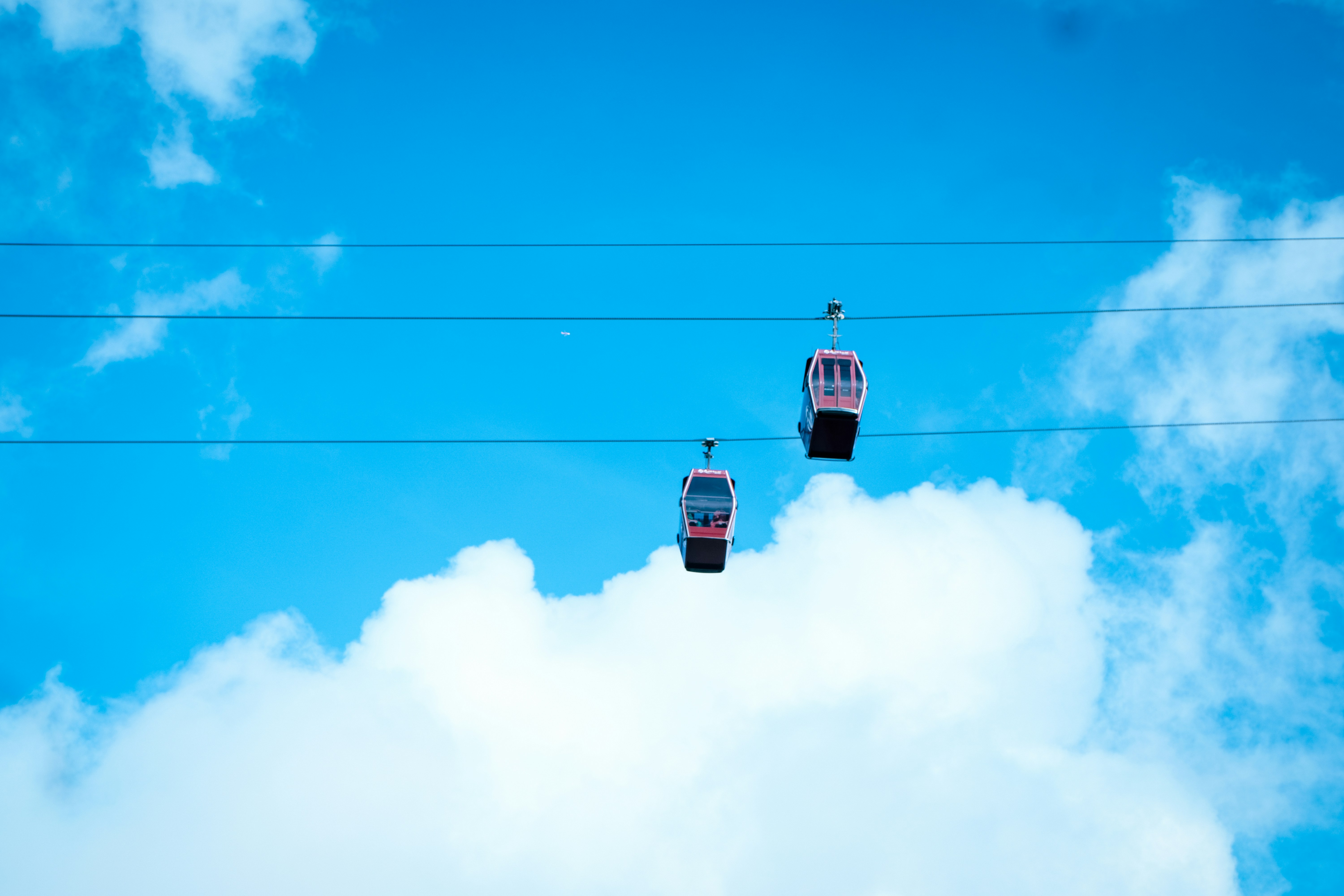 Cable Car Dream: Red Pods Glide Across a Cerulean Sky