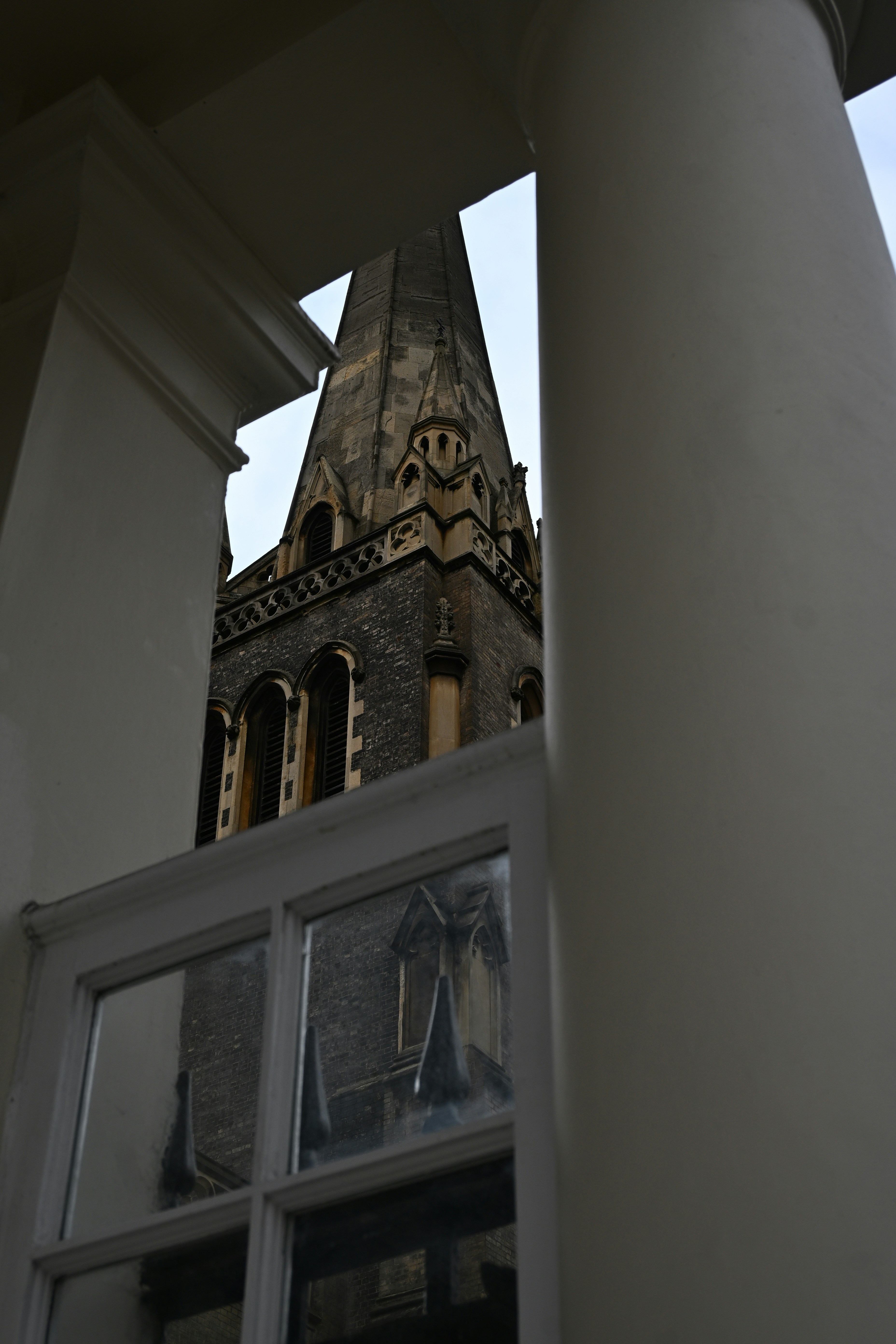 Gothic church spire seen through pillars and window