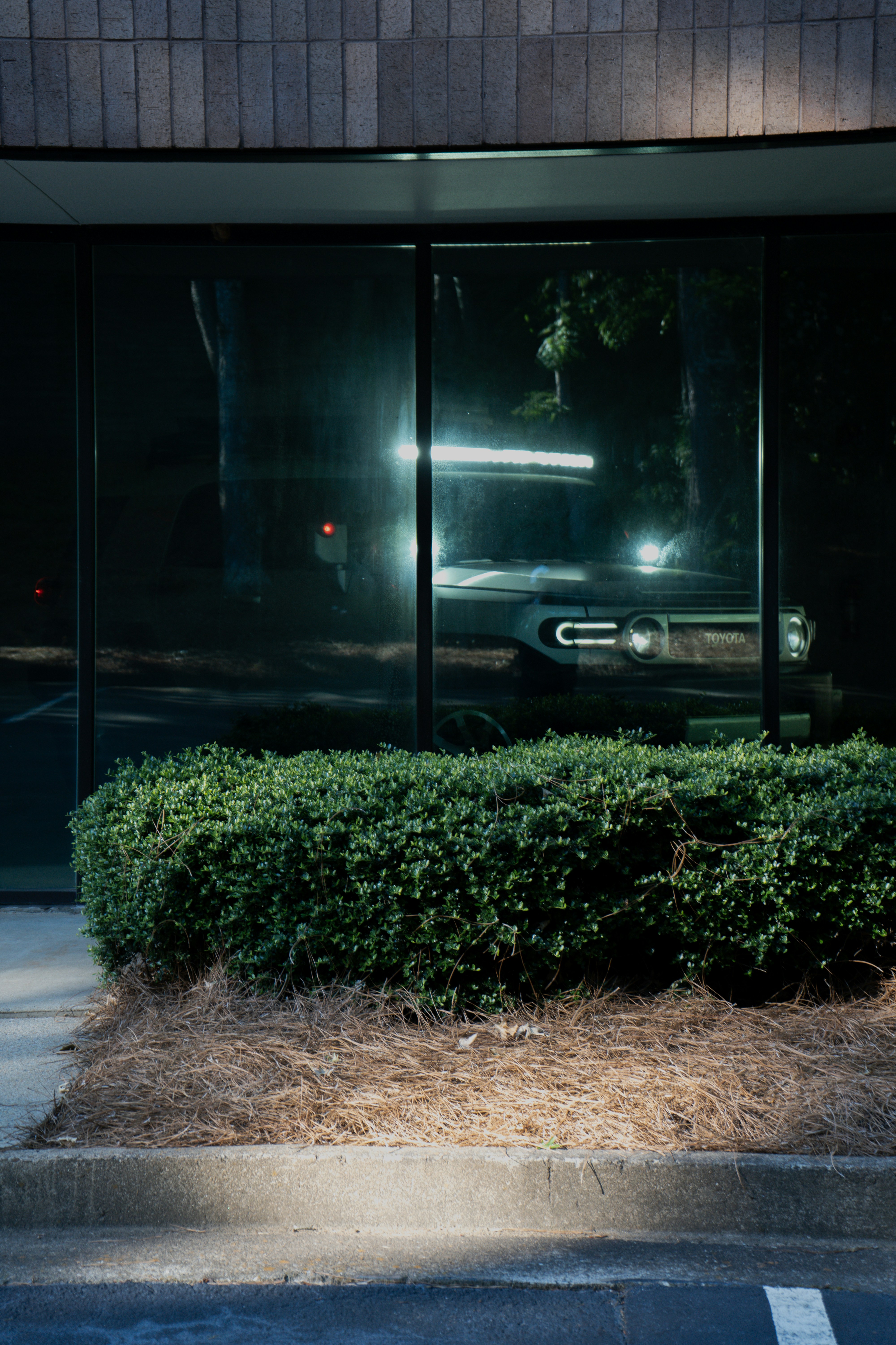 Nighttime Showroom: A Classic Car Reflected in Glass