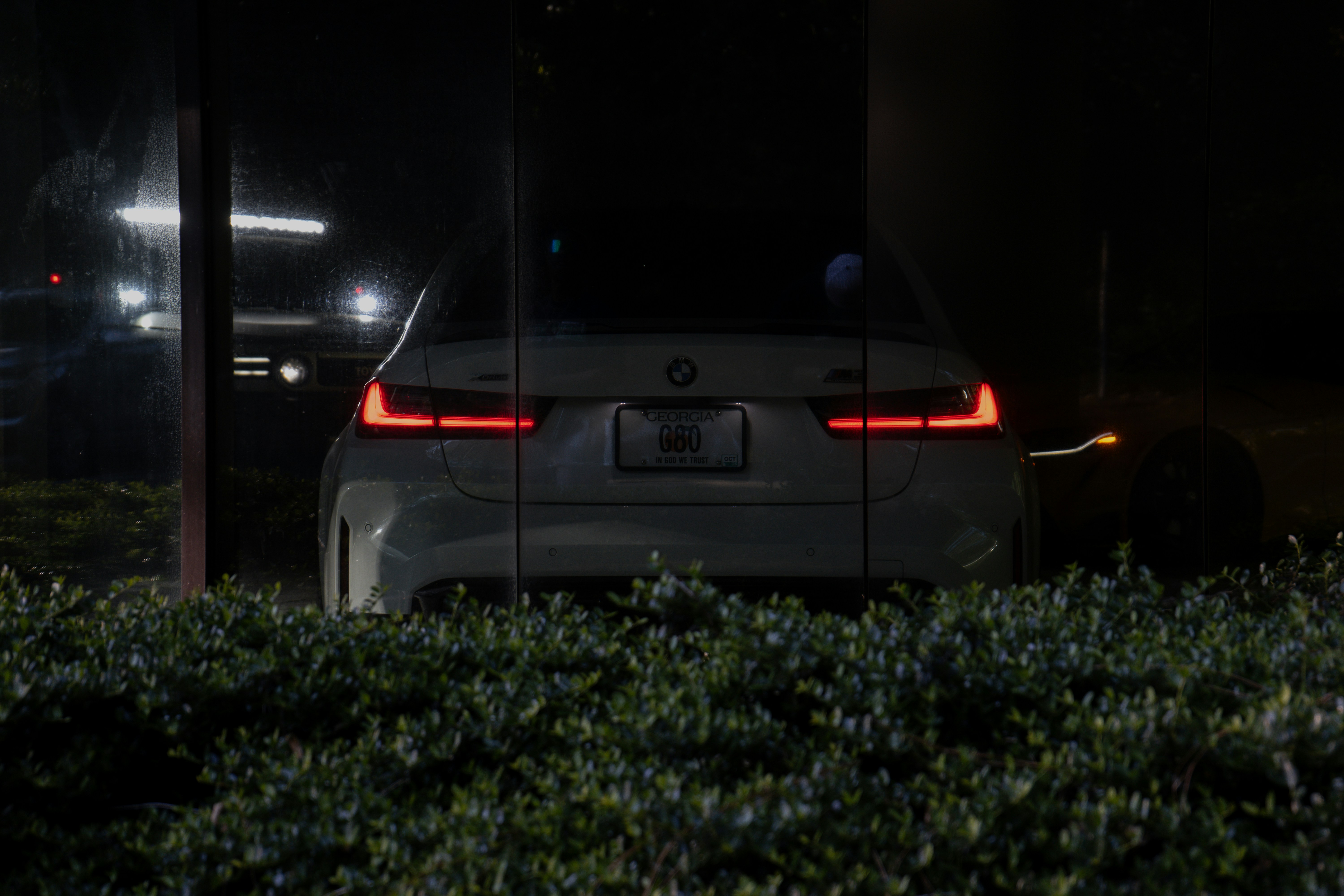 Rear-View in Neon Night: A BMW in Shadowed Parking