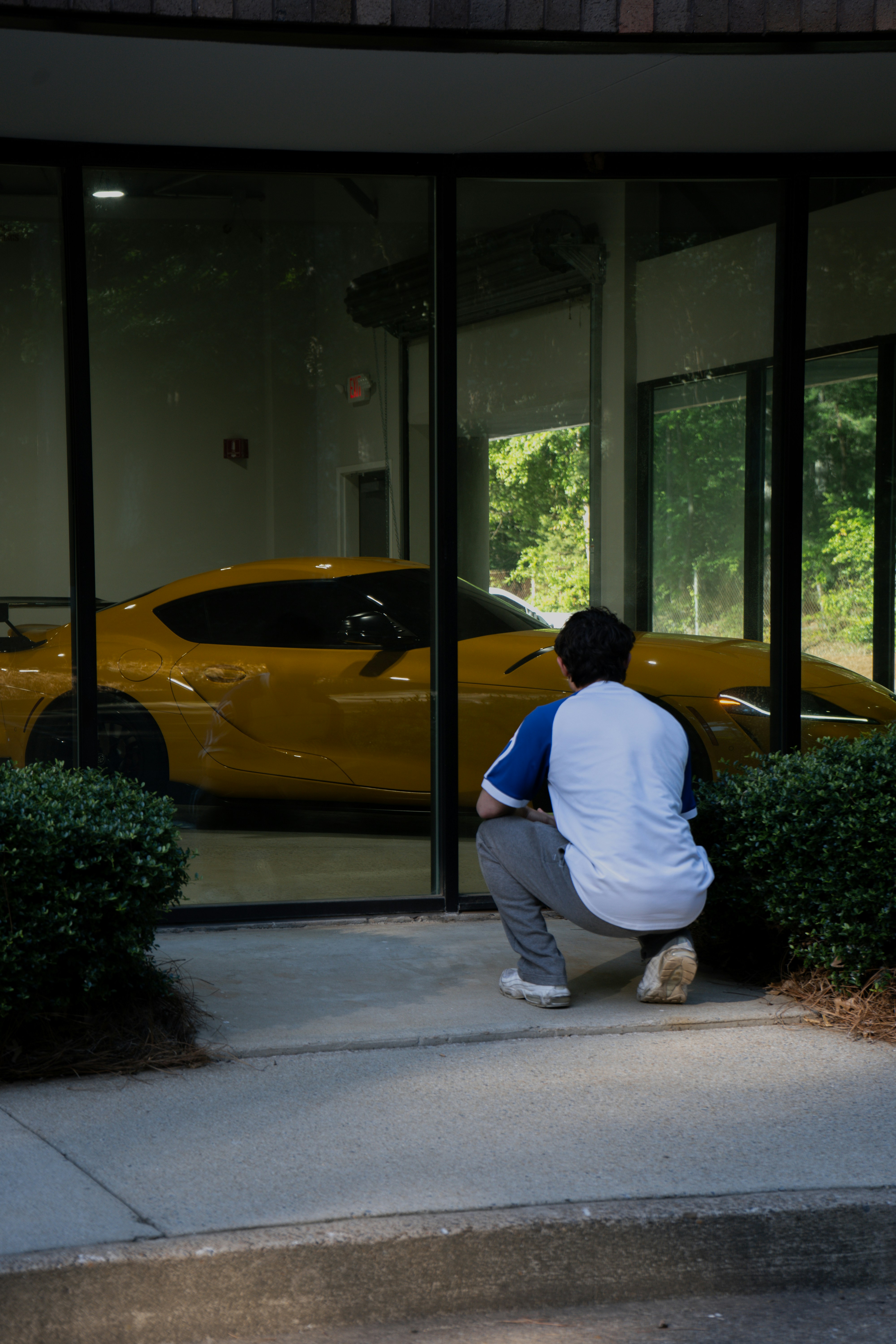 Squinting Future: A Quiet Moment with a Golden Car Behind Glass