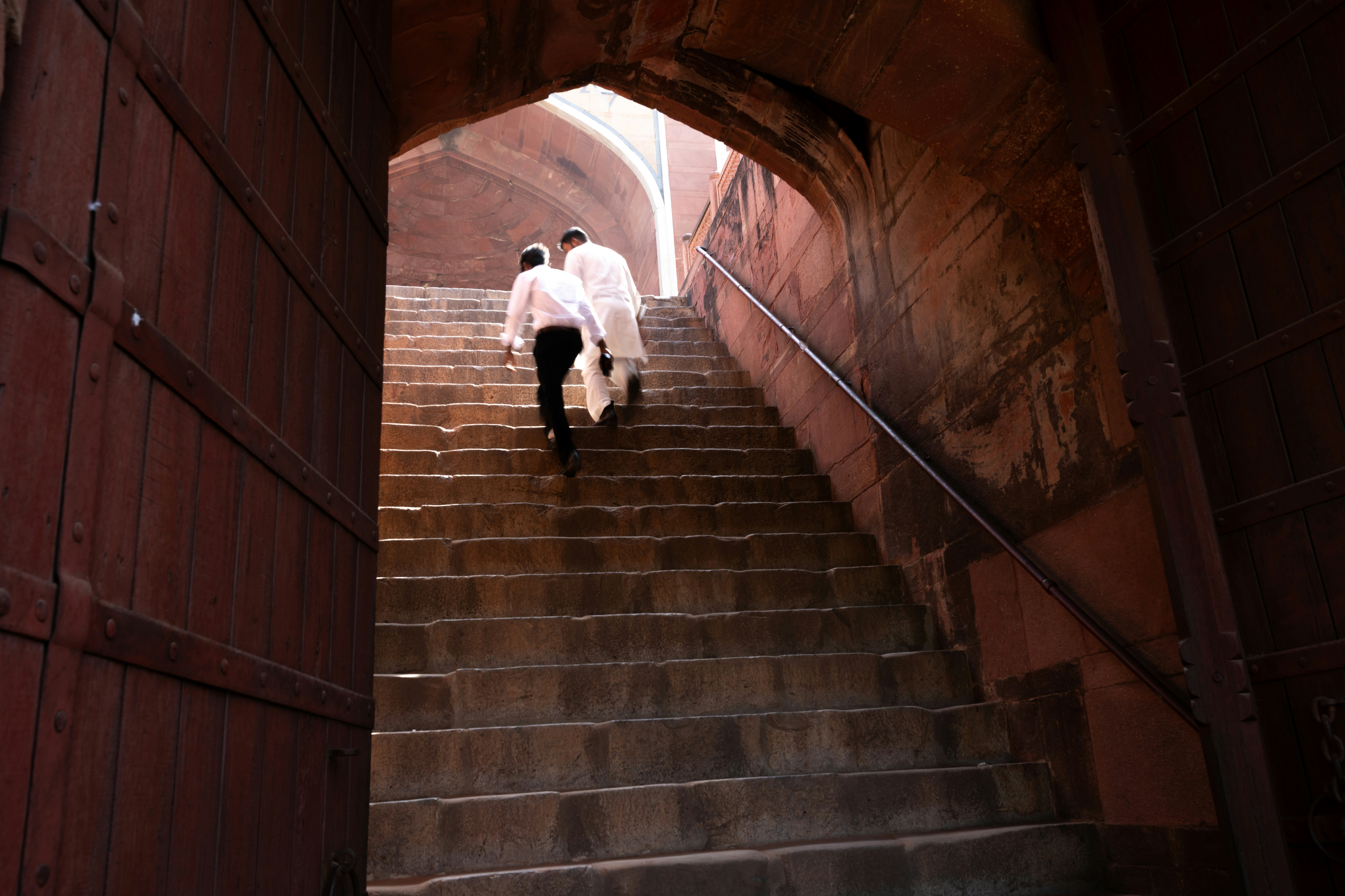 Ascending Toward Light: The Bride and Groom Climb a Brick Stairway