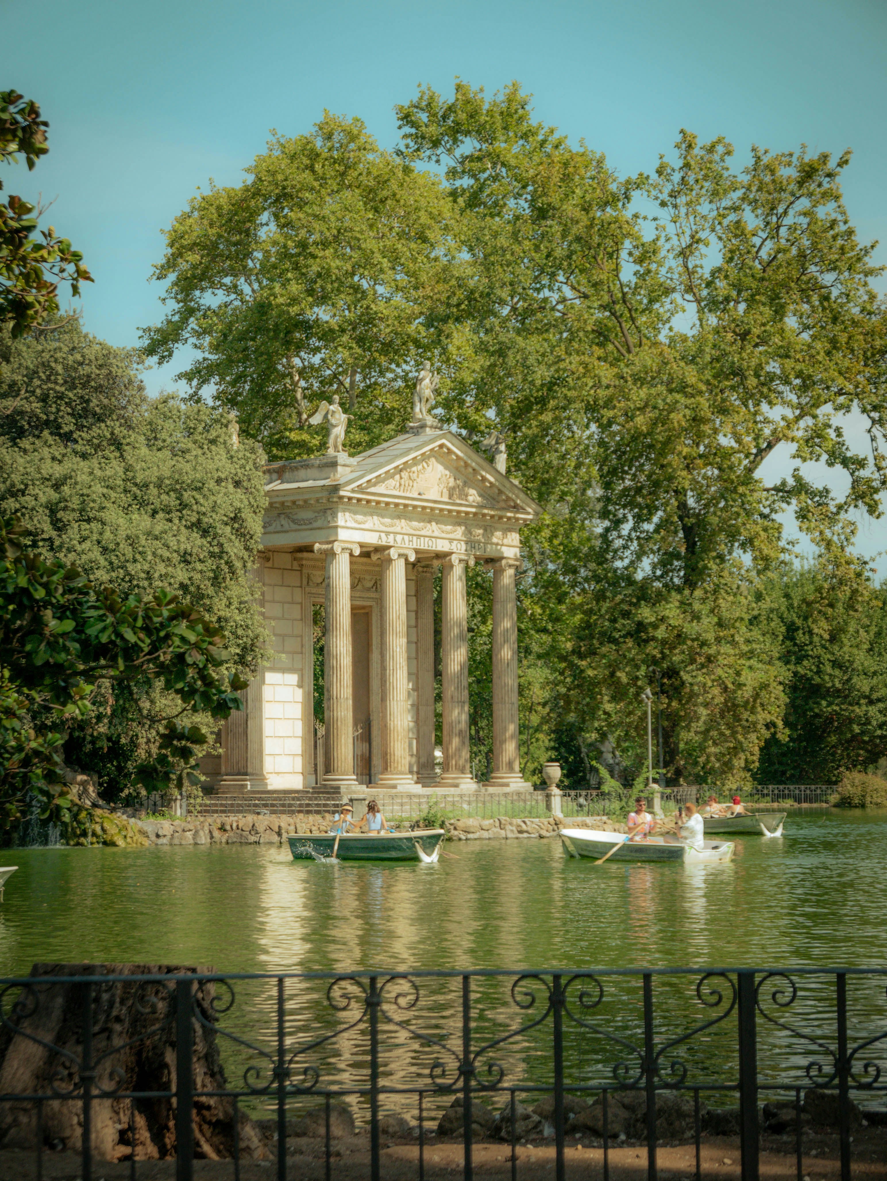Temple on the Water: Boats Glide by a Classical Riverside Pavilion