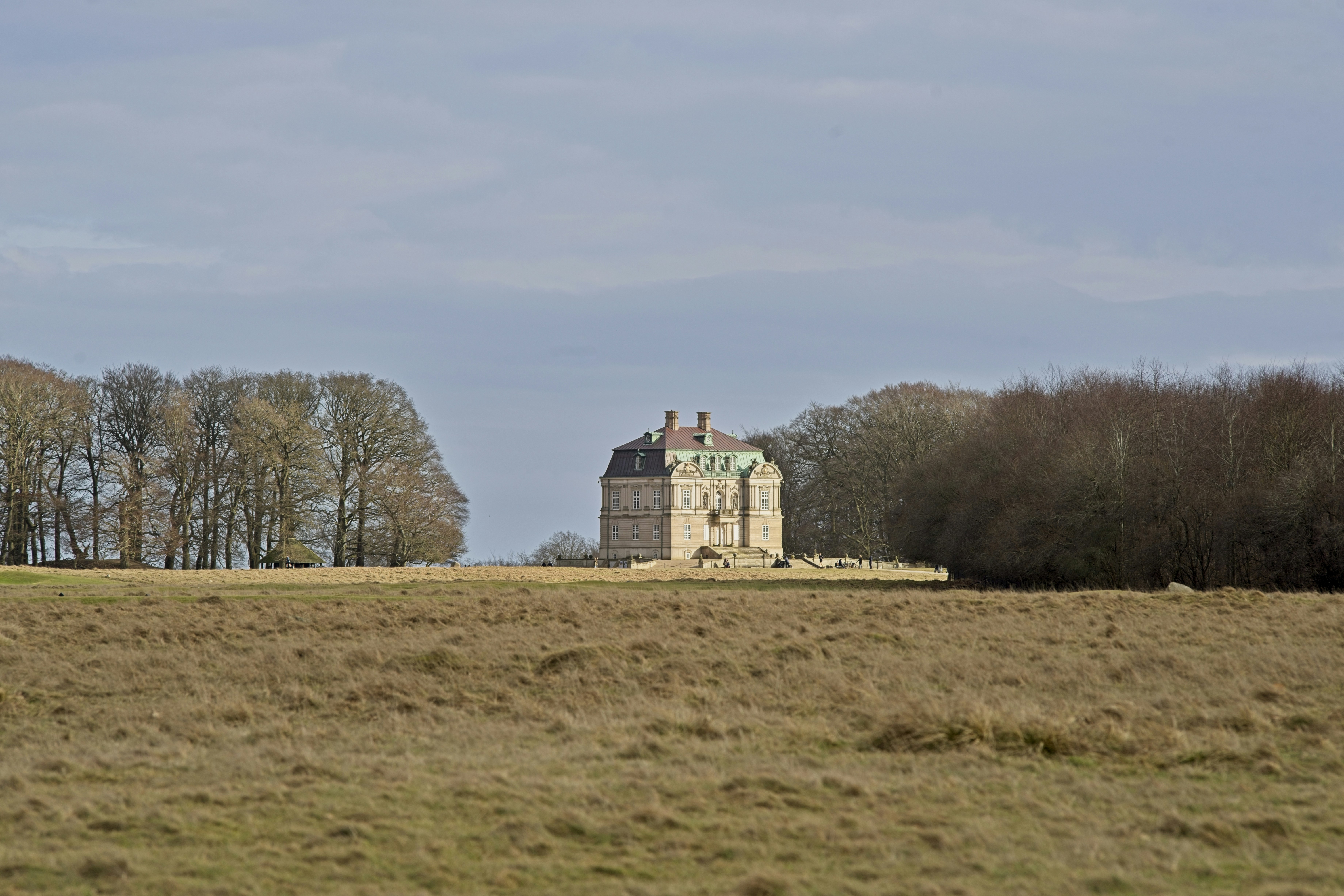 A solitary manor rising from a windswept plain