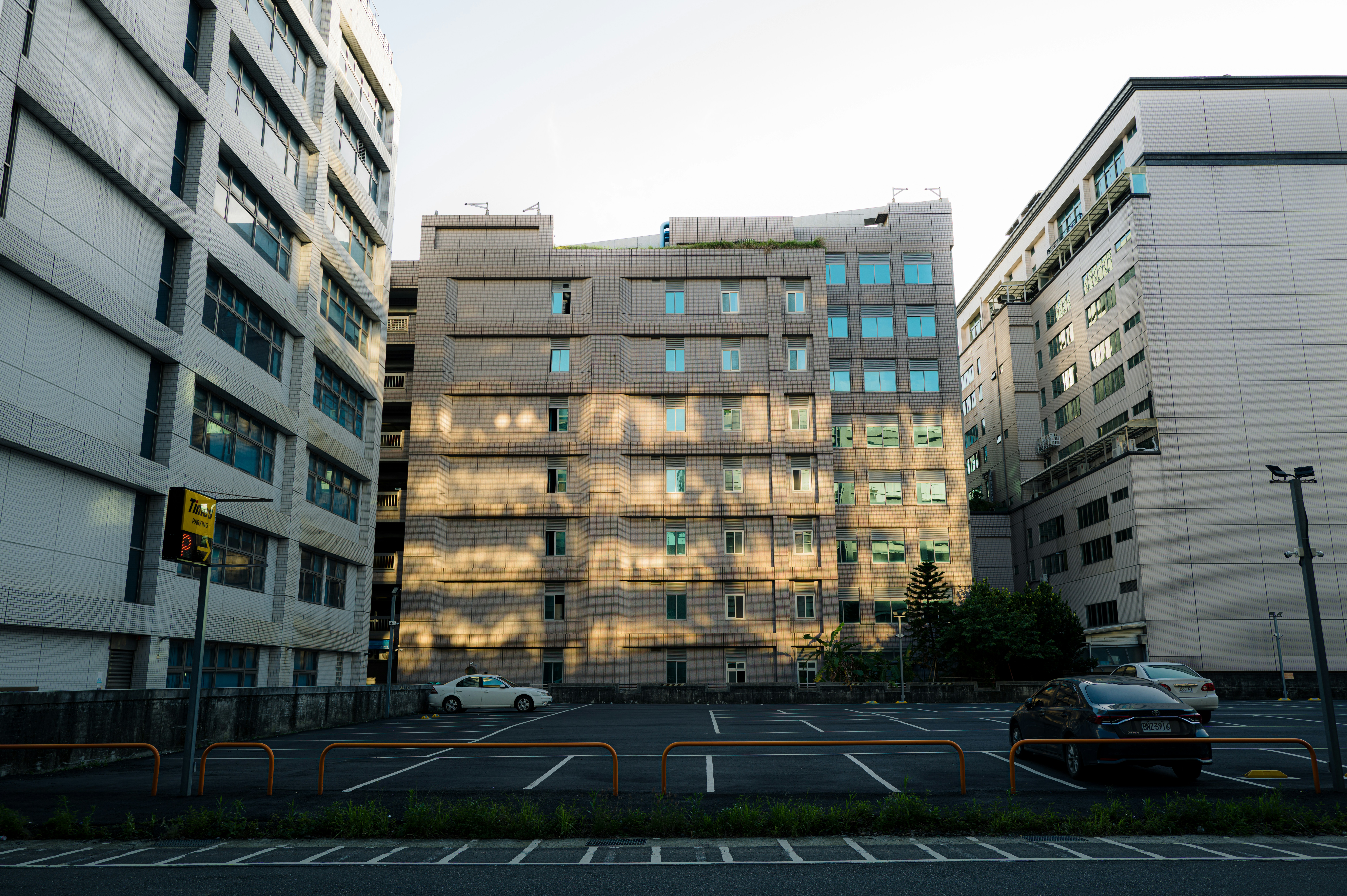 Sunlit Facade Echoes: A Quiet City Parking Courtyard