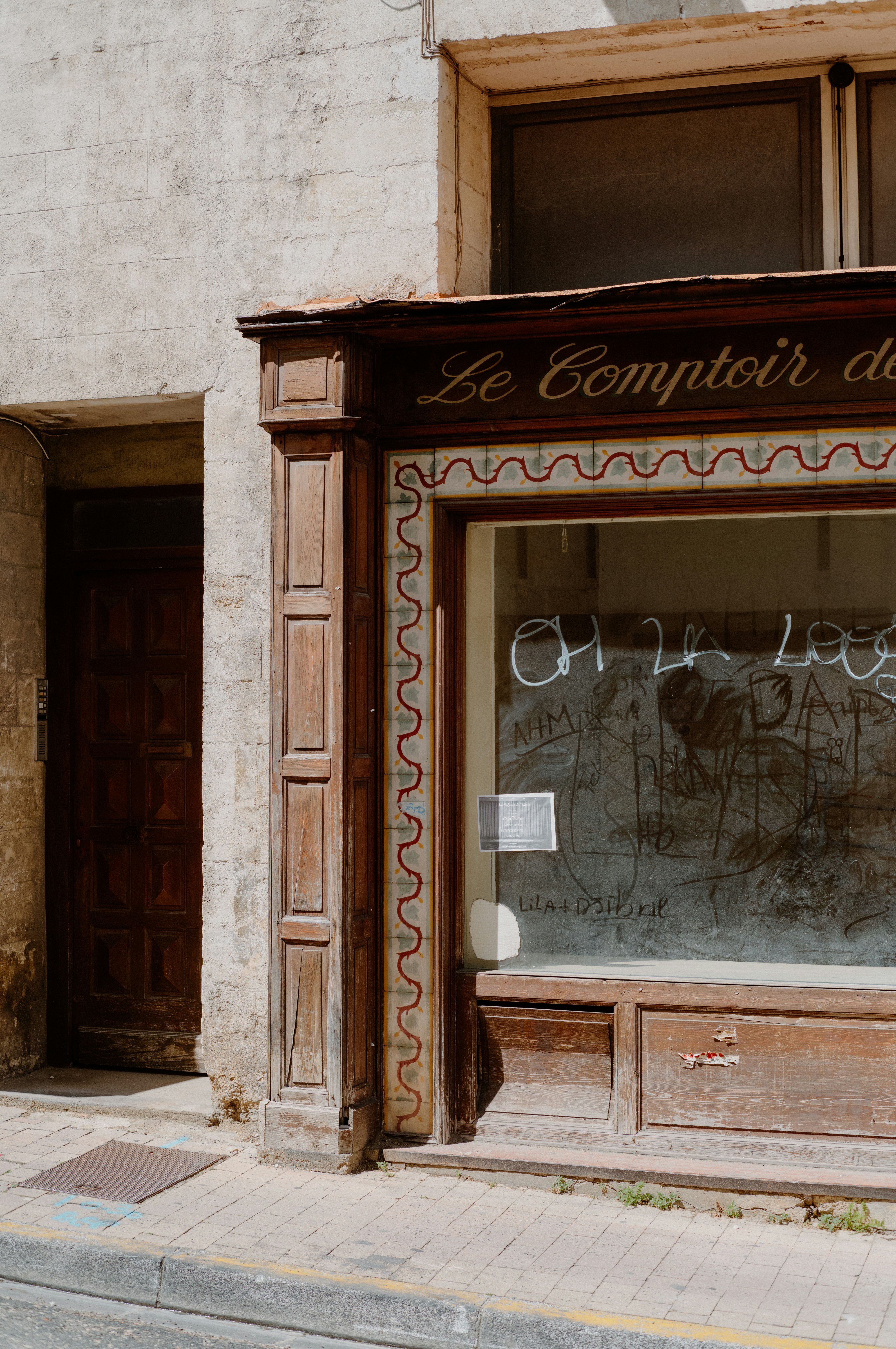 The Crumbling Facade of Le Comptoir: Graffiti and Time in a Quiet Street
