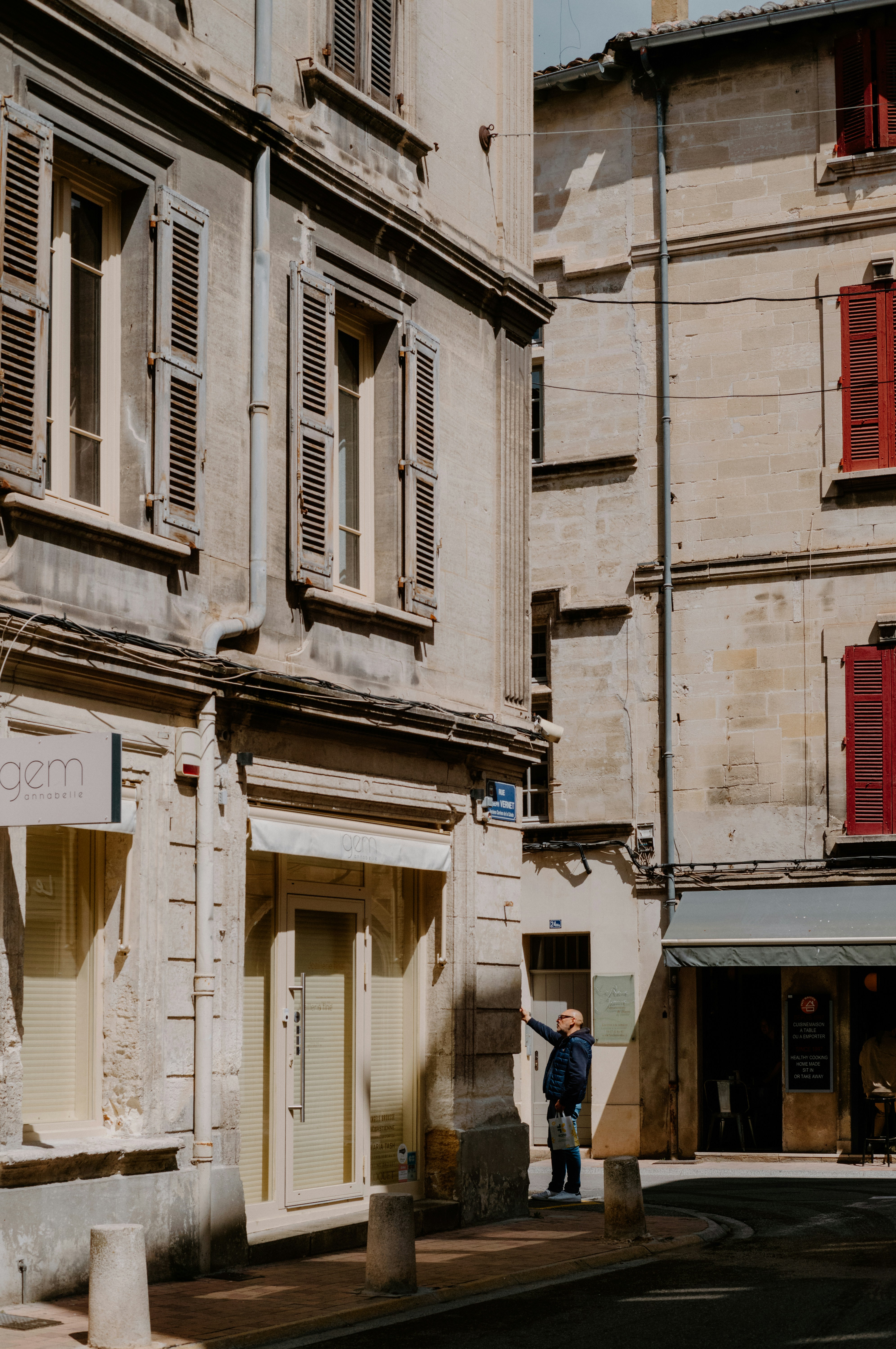 Sunlit Street Portrait: A Pedestrian Commuter by the Historic Facade
