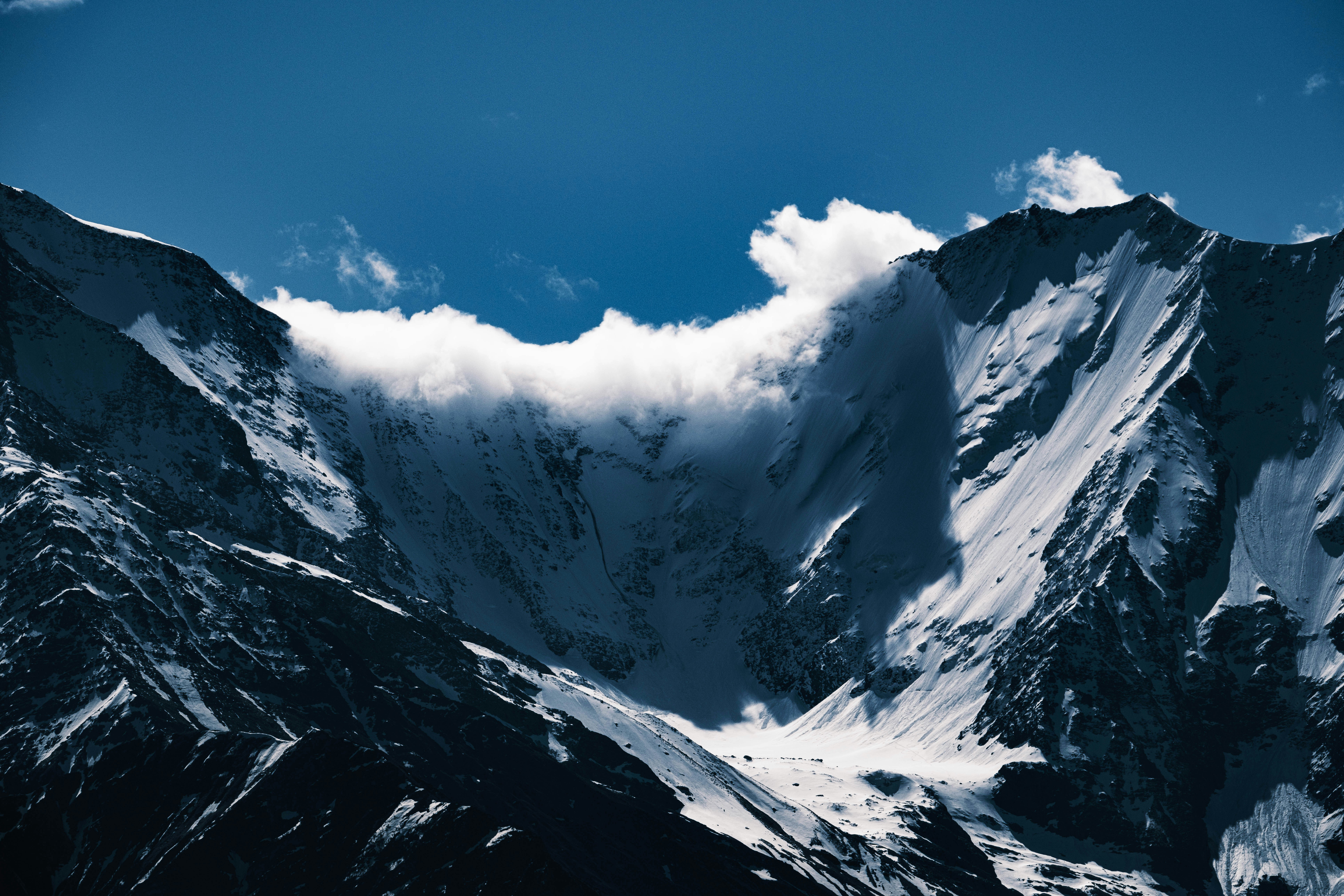 Snow-rimmed Peak Crowned by a Stratus Crest