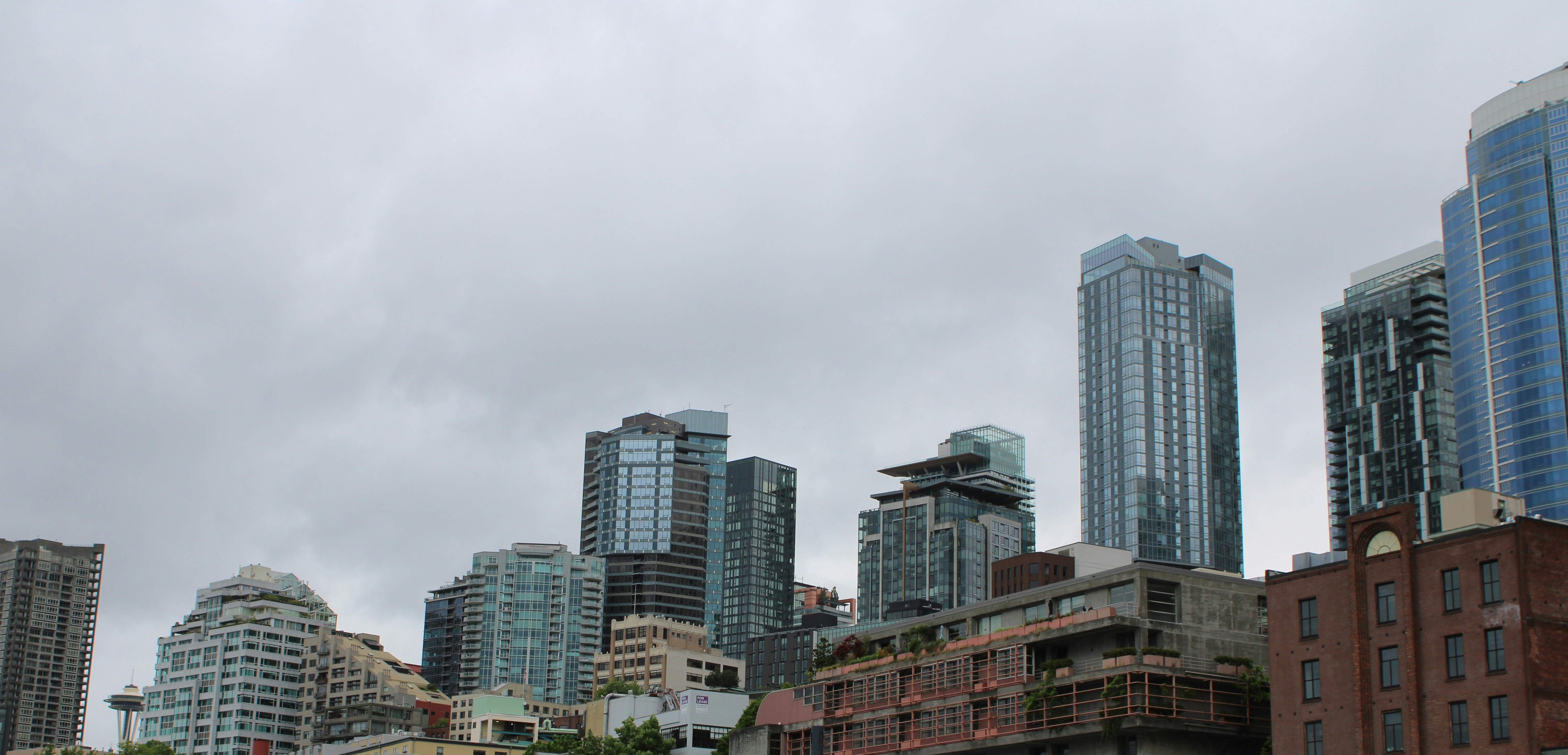 Urban Skyline at Dusk: Towers Rising over Brick Industrial Walls