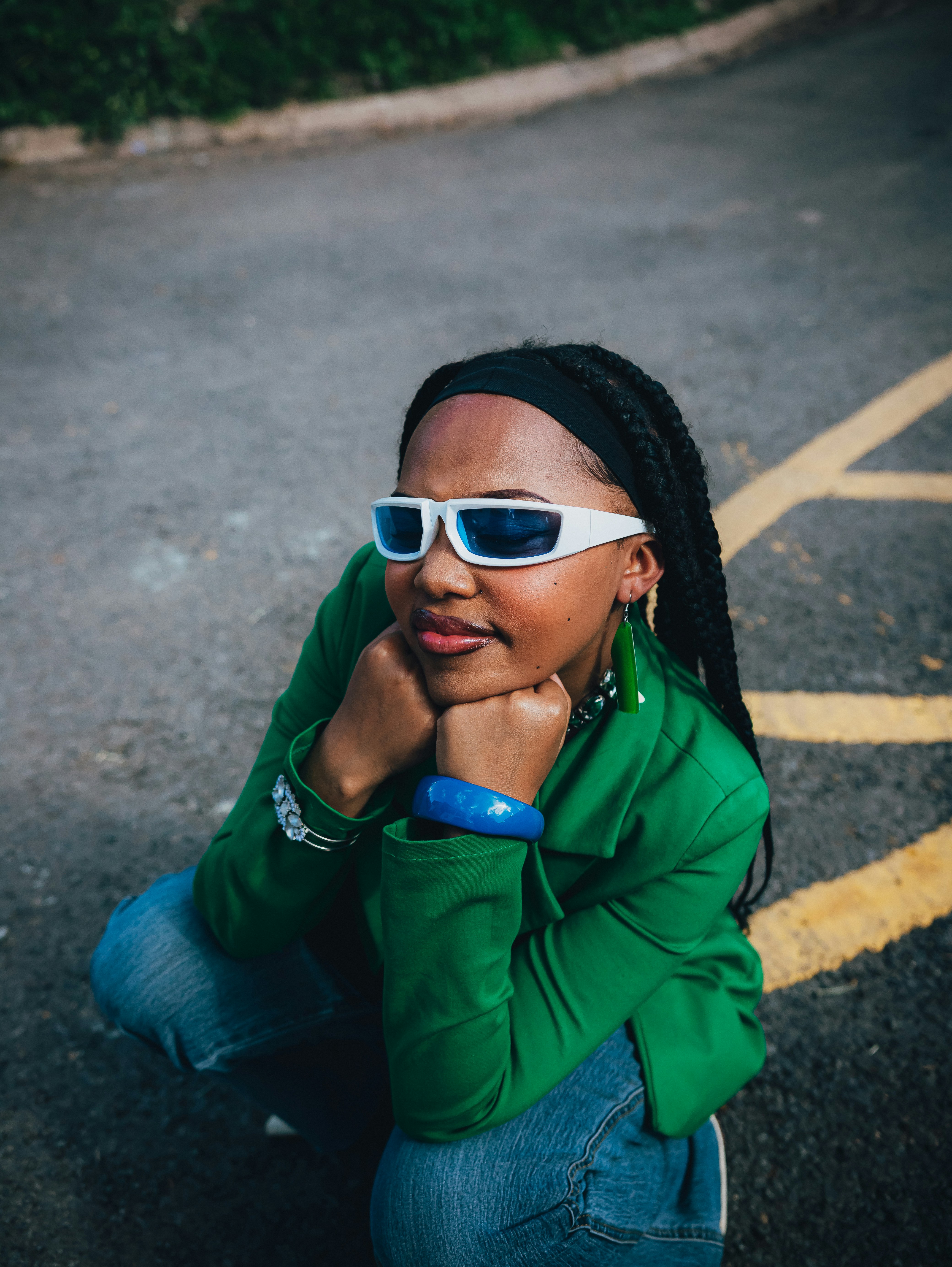 Green blazer, bold frames: a confident pose in the parking lot