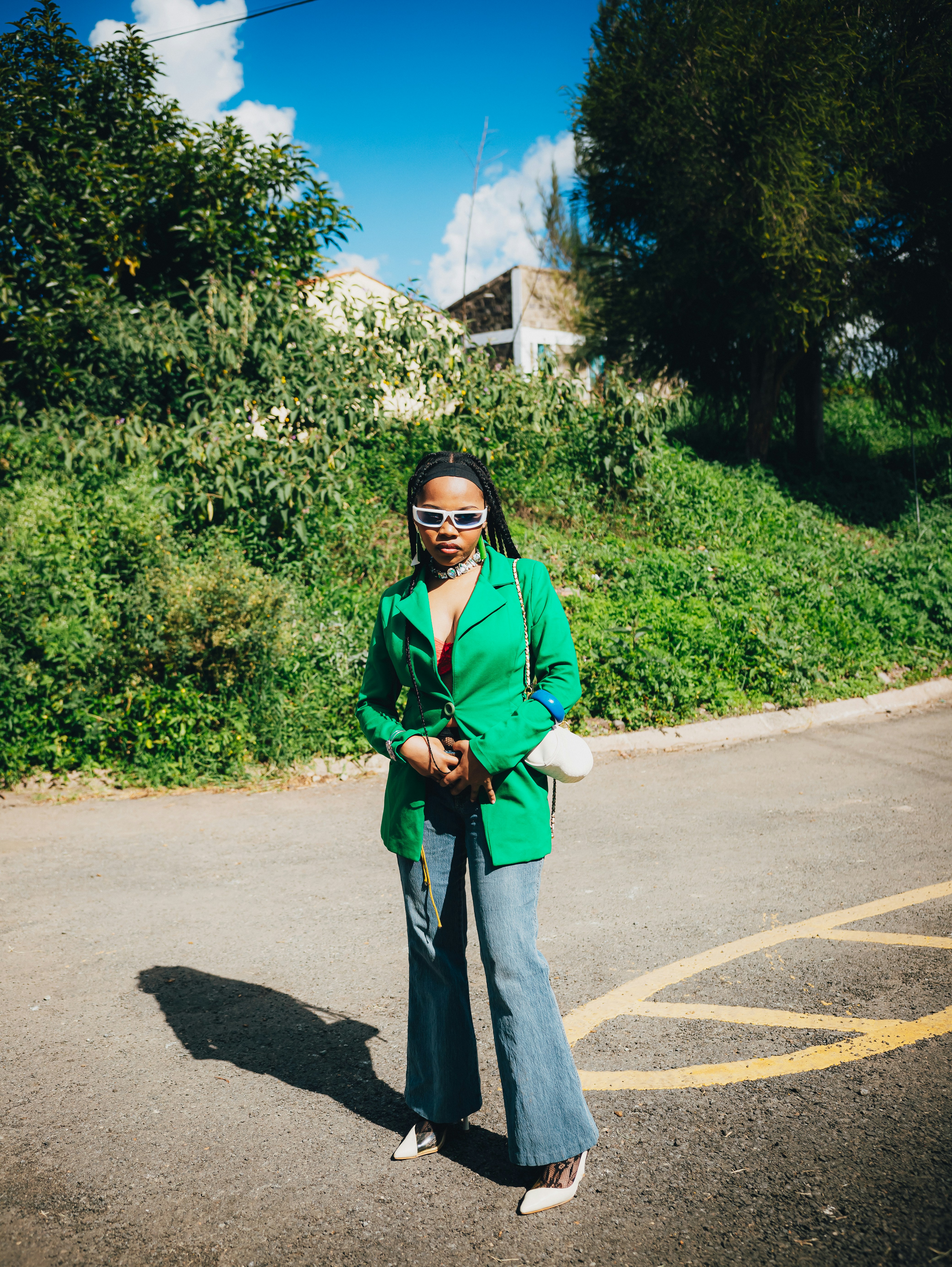Green blazer, bold stance: a street portrait under bright sky