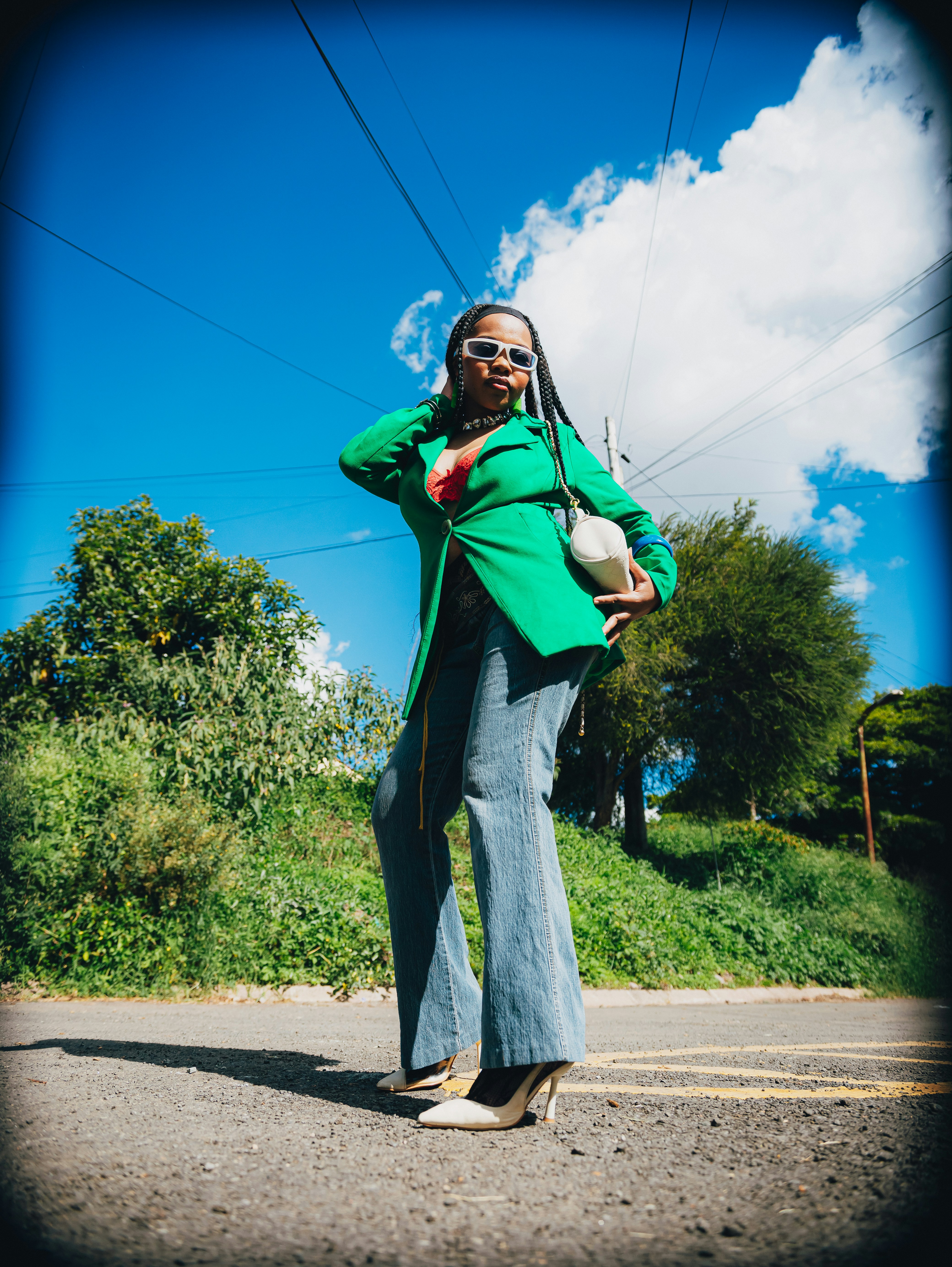 Bold stride under electric blue sky: a street-style portrait in green