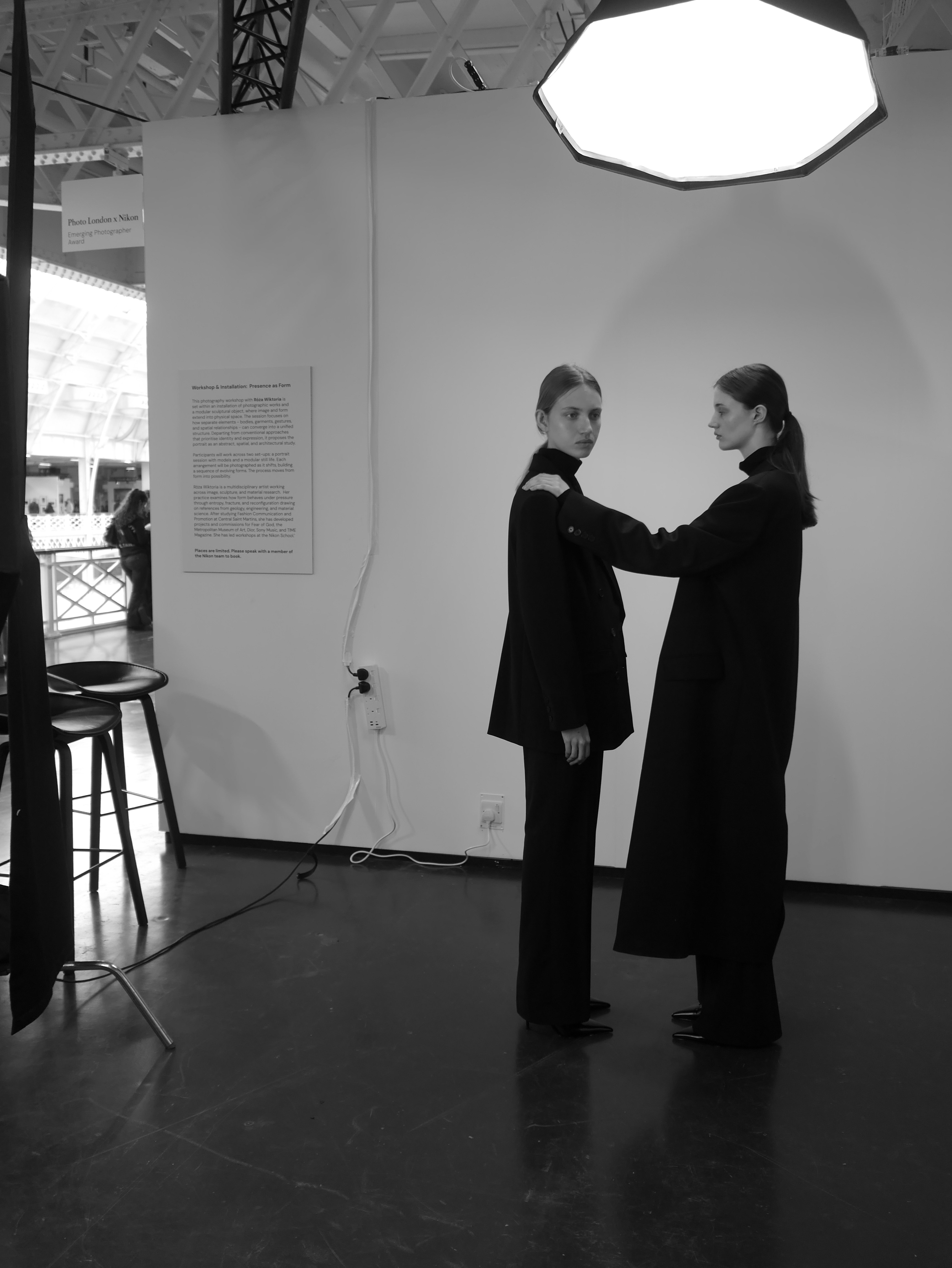 Silhouetted Studio Moment: Two Models in Conversation Under Harsh Studio Light