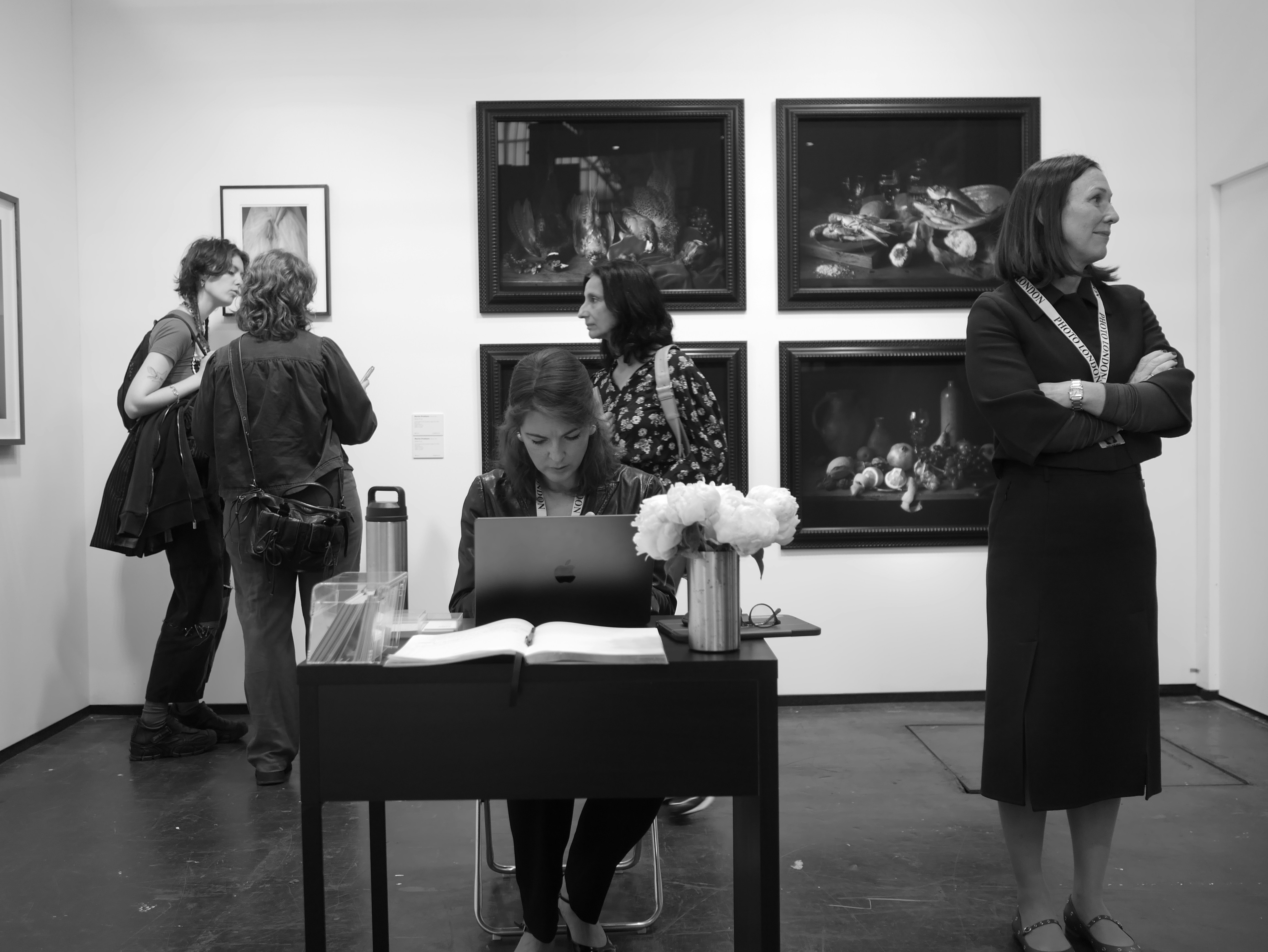 Quiet Productivity in a Gallery: A Woman at the Desk Amid Curated Frames