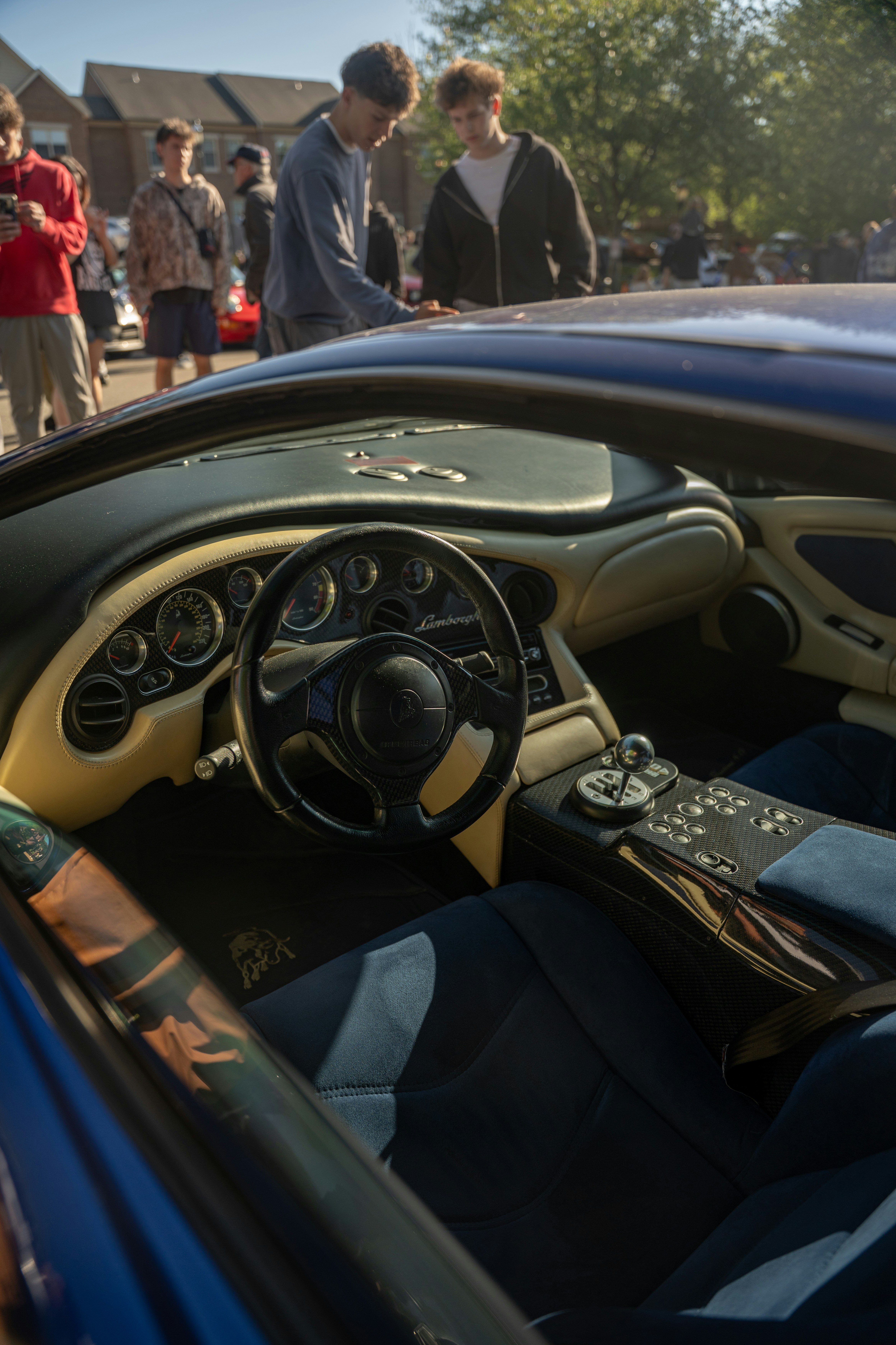Sports car interior with cream dashboard and blue seats.