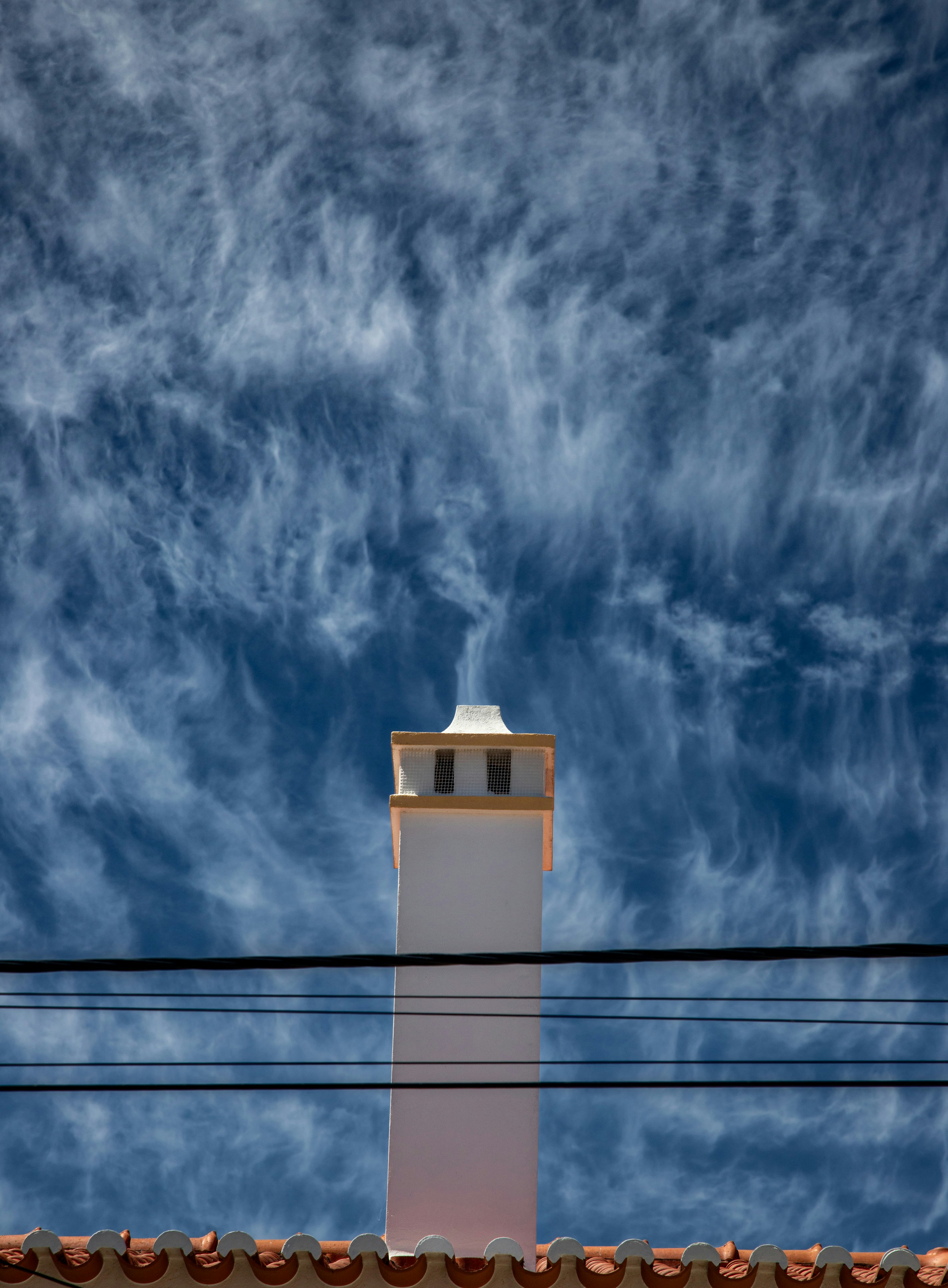 Chimney Against a Sky of Feathery Clouds