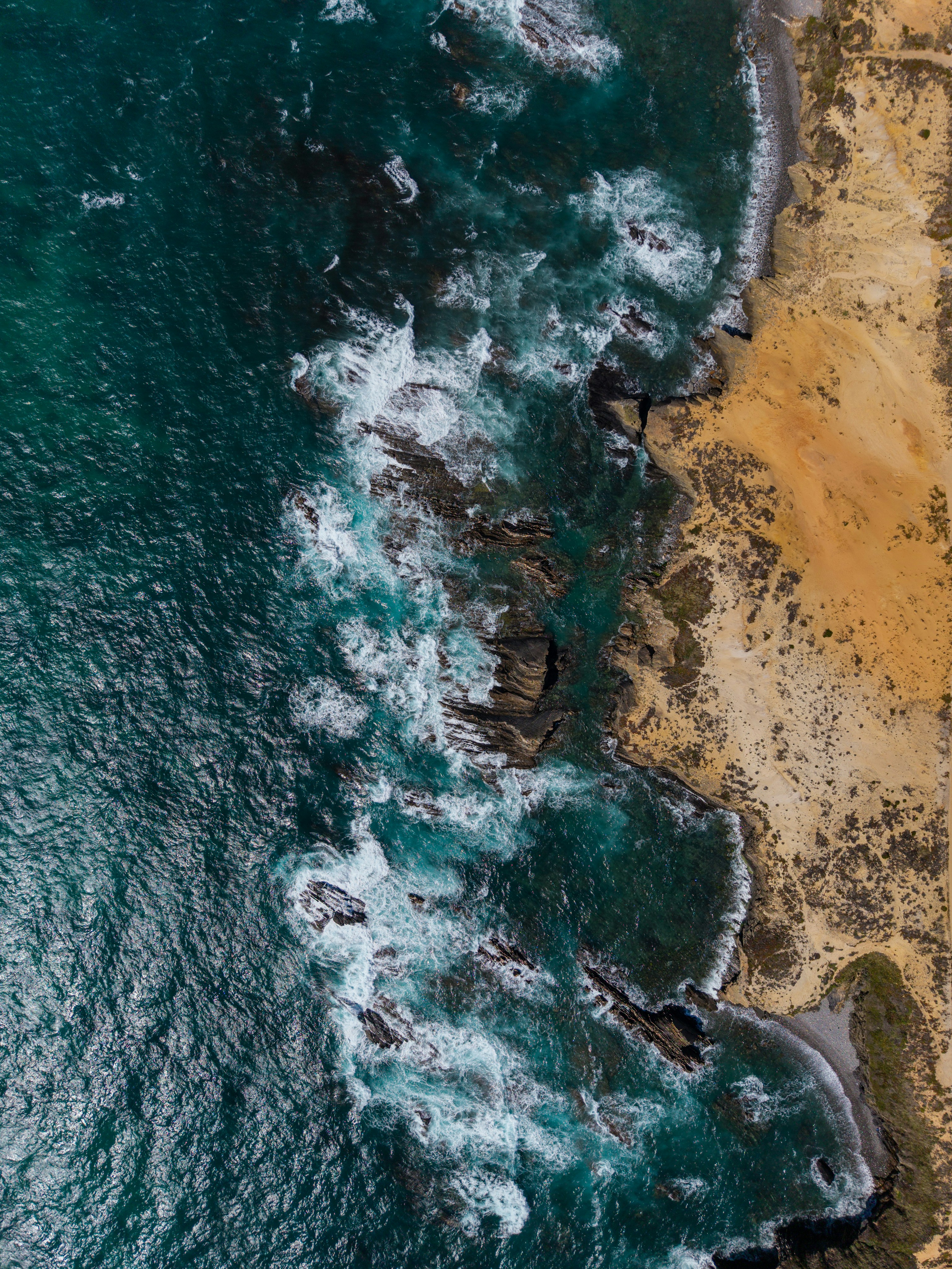 Rugged Coastline: Turquoise Surge Meeting Golden Cliffs