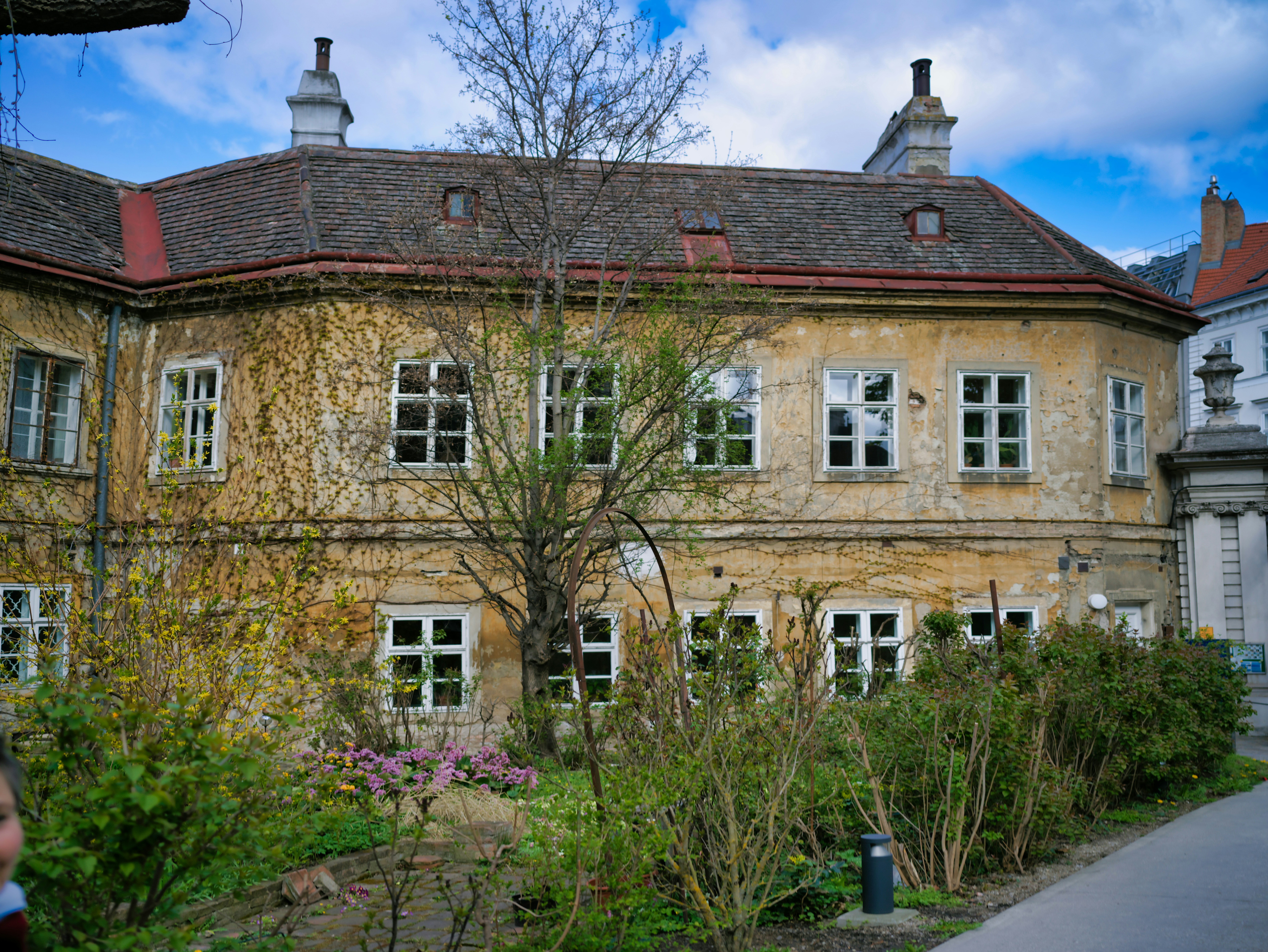 A ivy-draped manor rises above a quiet garden