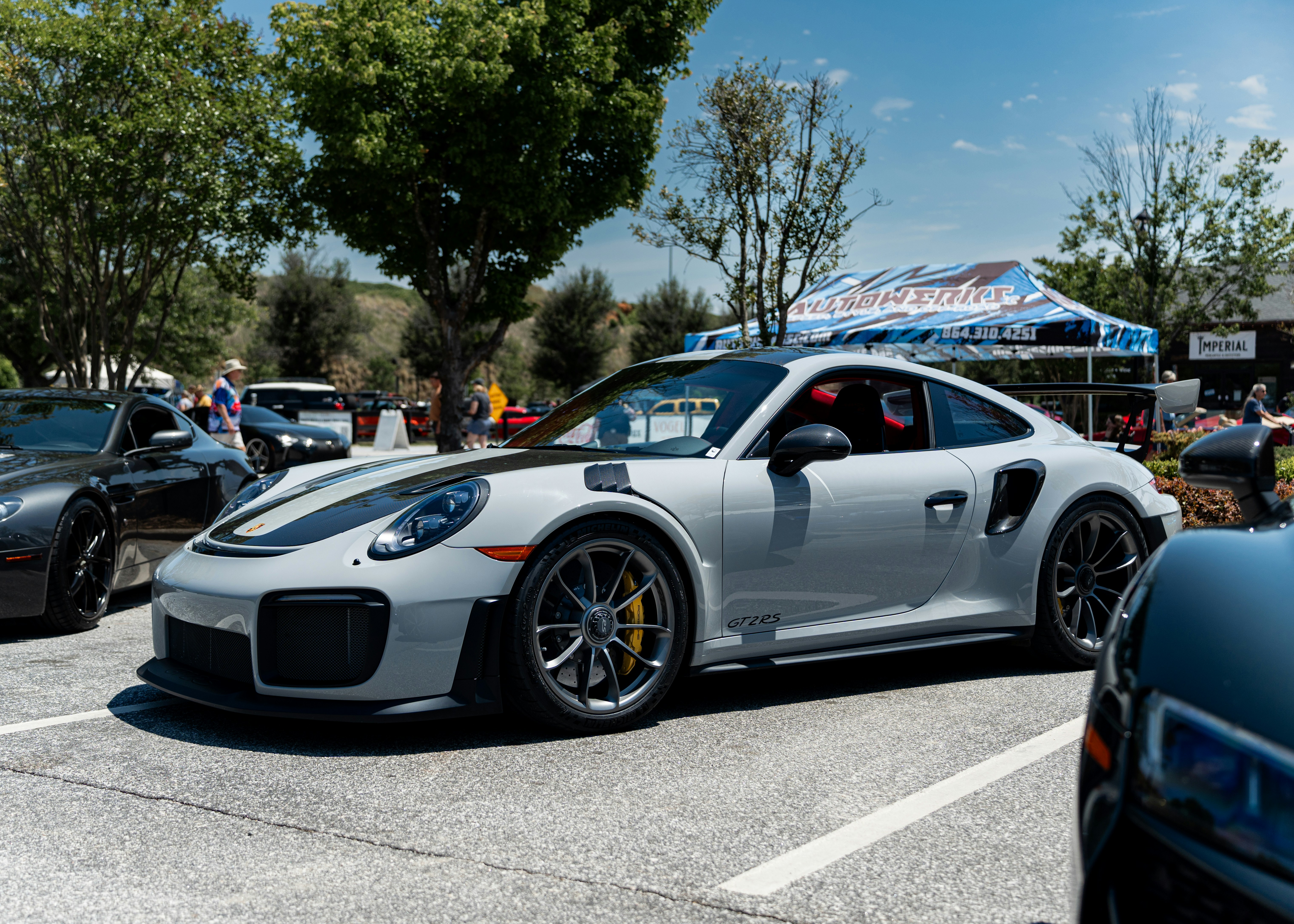 Silver Porsche Stands Centerstage at Car Show Under Bright Summer Sky
