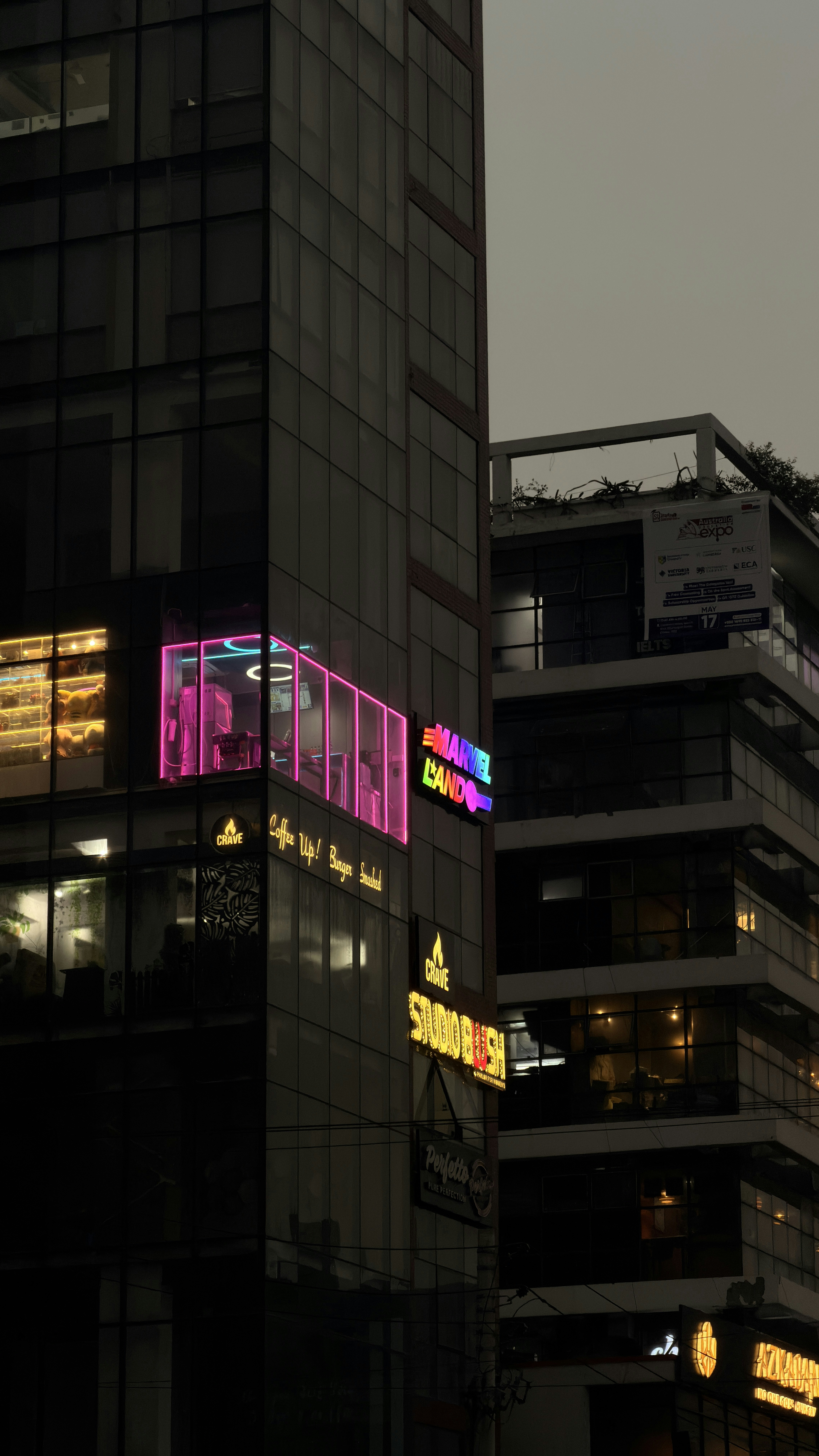 Neon Glint on Glass: Evening Facade of a Modern Loft District