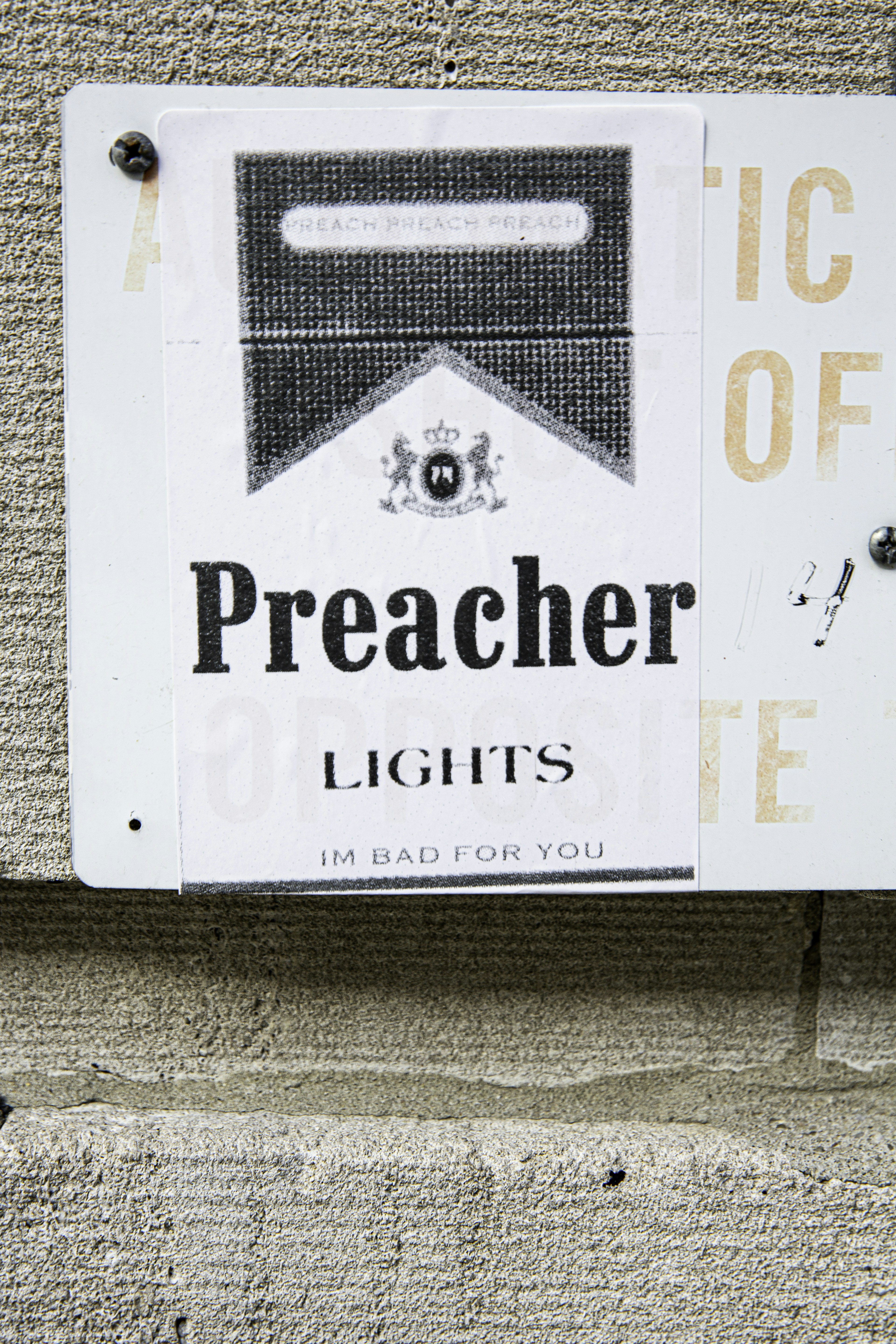 Preacher Lights: A Weathered Sign Adrift on Concrete