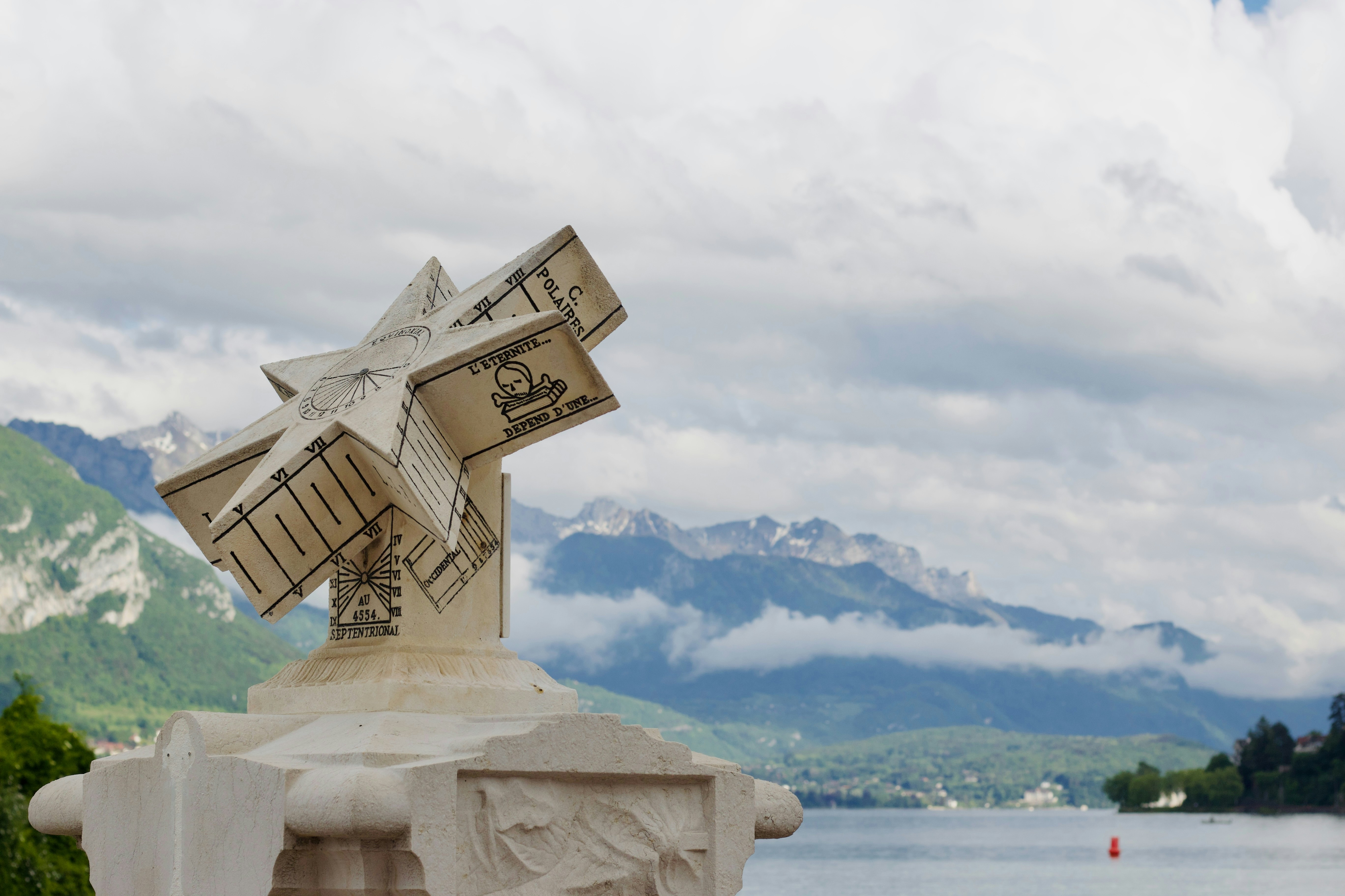 Stone Star on the Lake: A Monumental Compass Against Alpine Backdrop