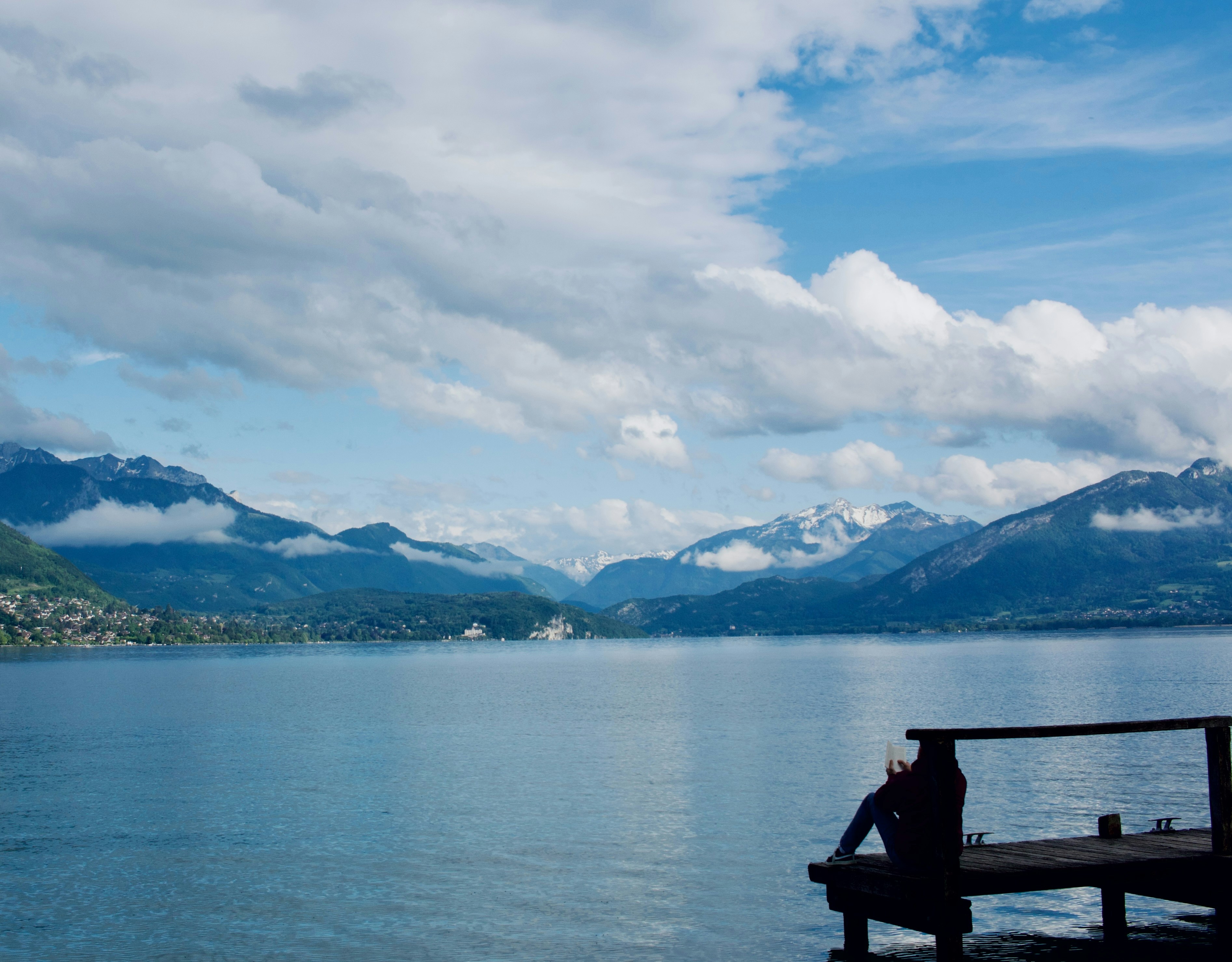 Quiet Lake Vista: A Solitary Figure at the Pier Against Alpine Silence