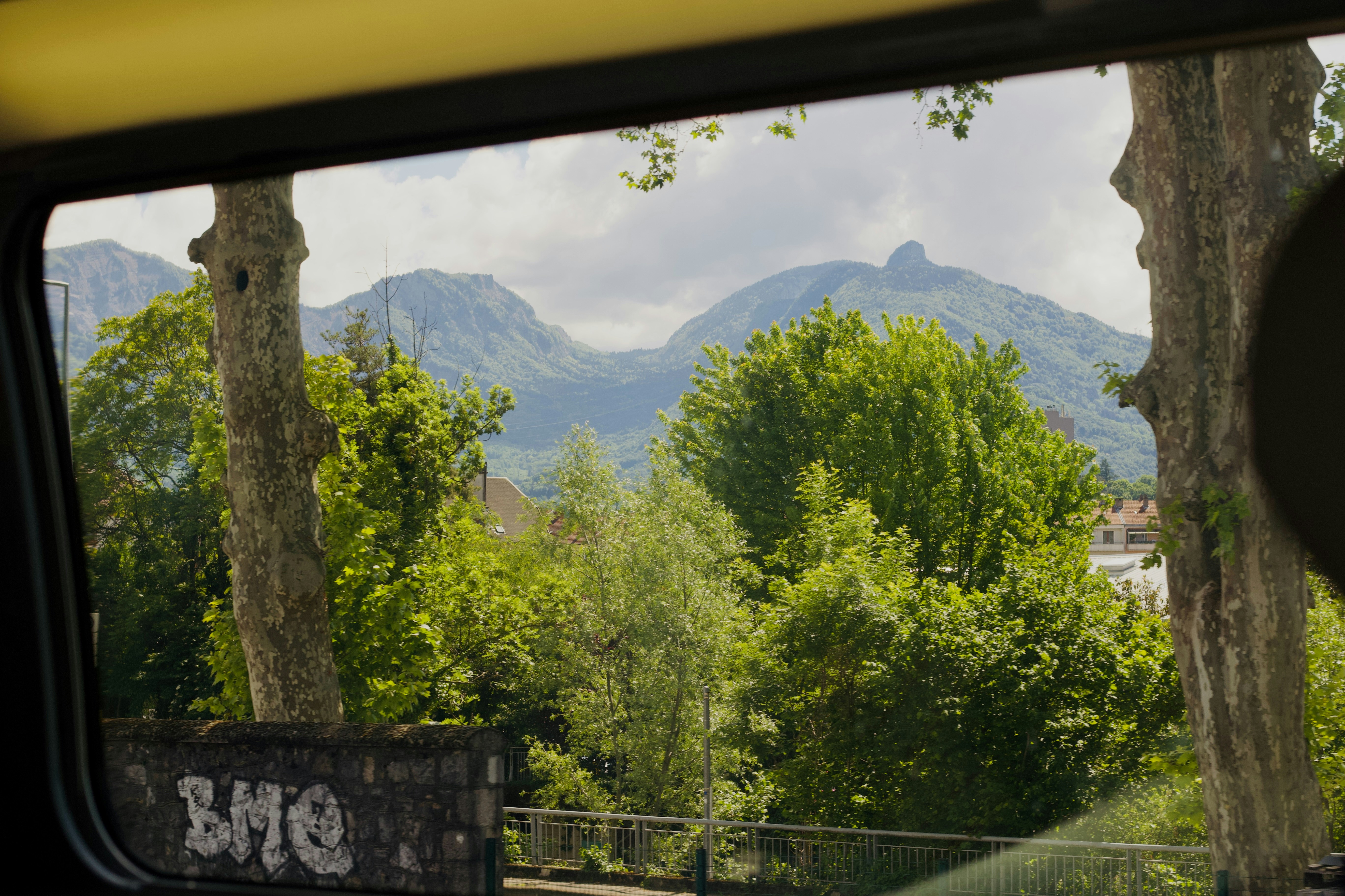 Framed Beyond the Window: Mountain Backdrop Through a Bus Window
