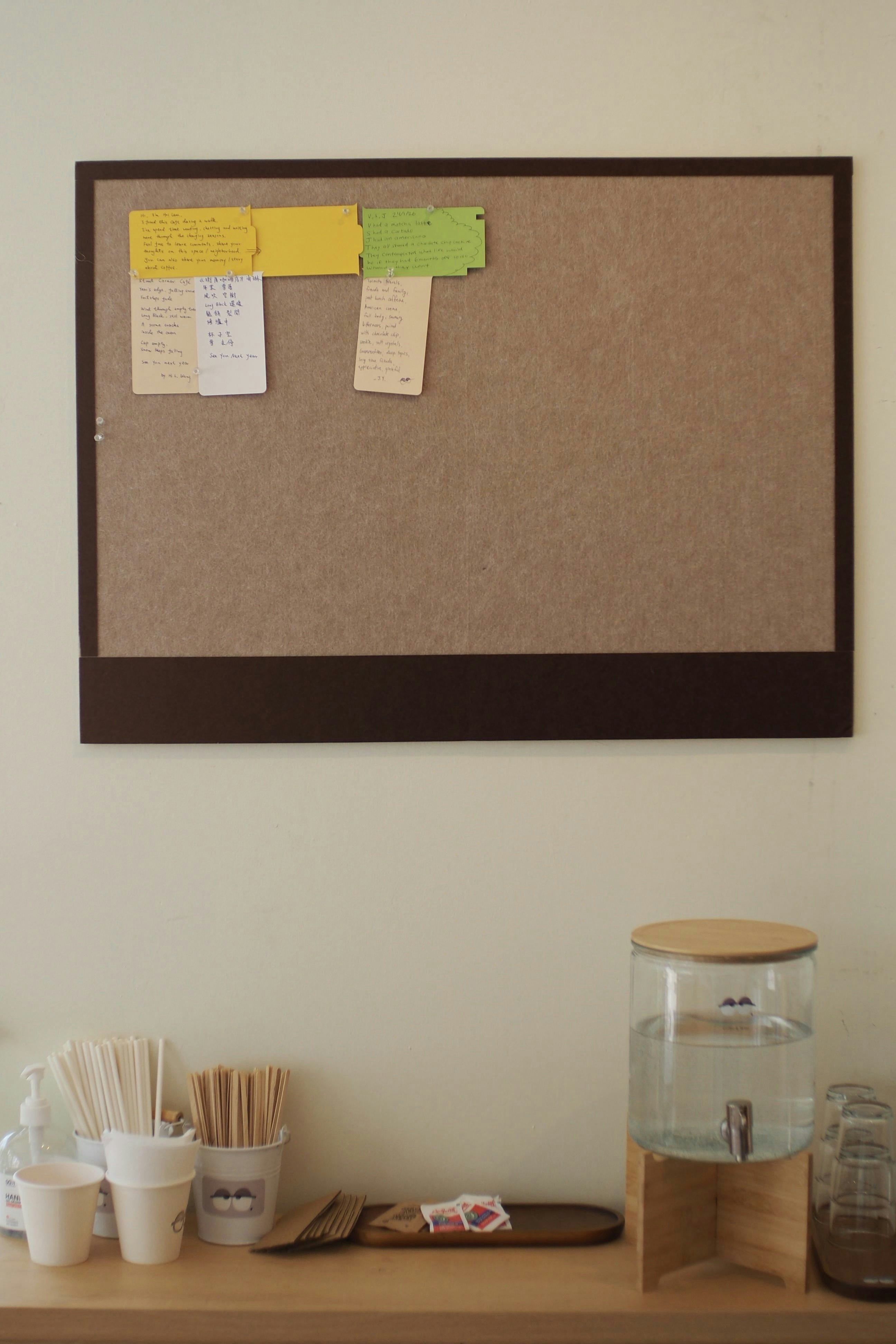 Corkboard with notes above coffee station supplies